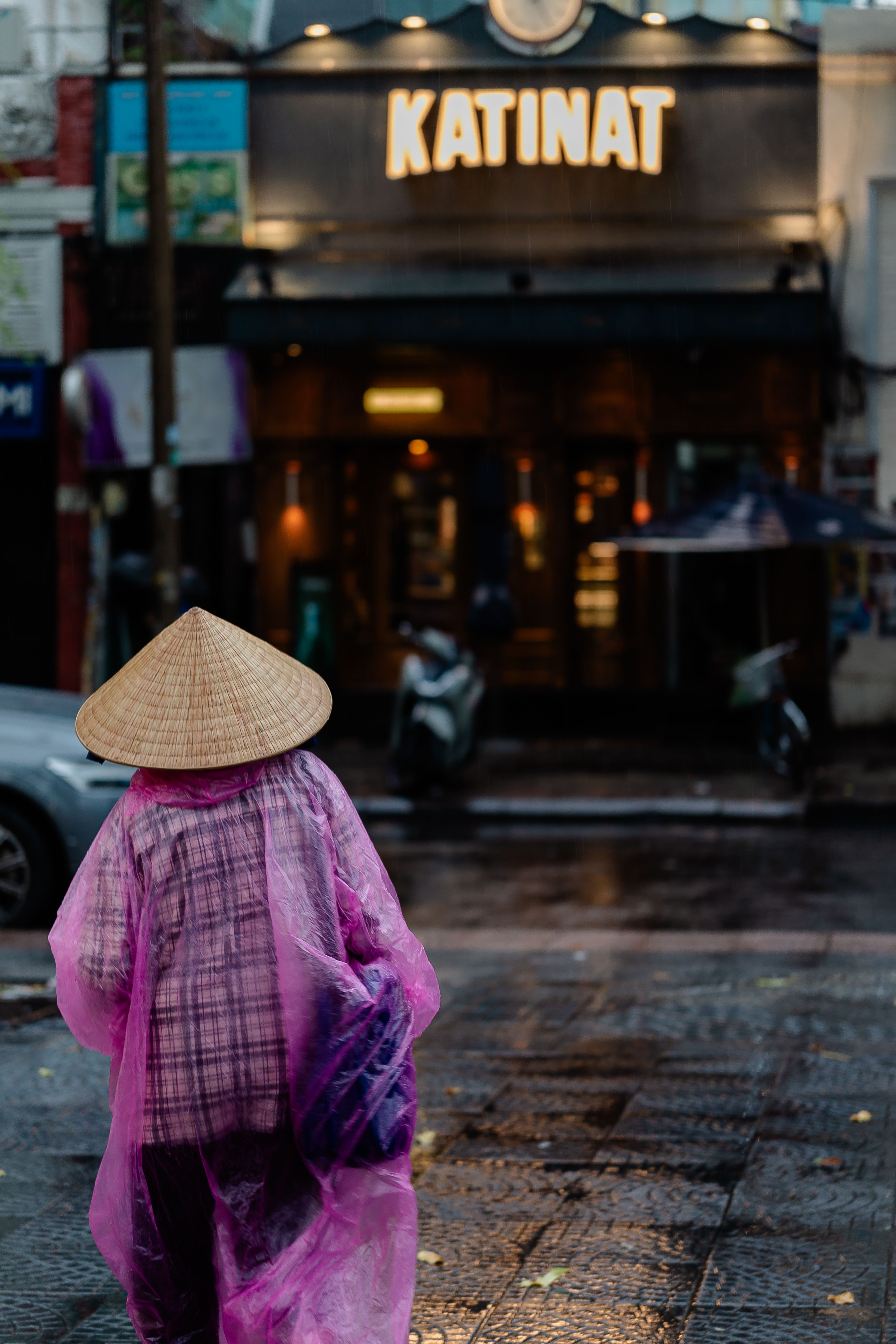 Rainy Street Scene with Conical Hat and Café · Free Stock Photo