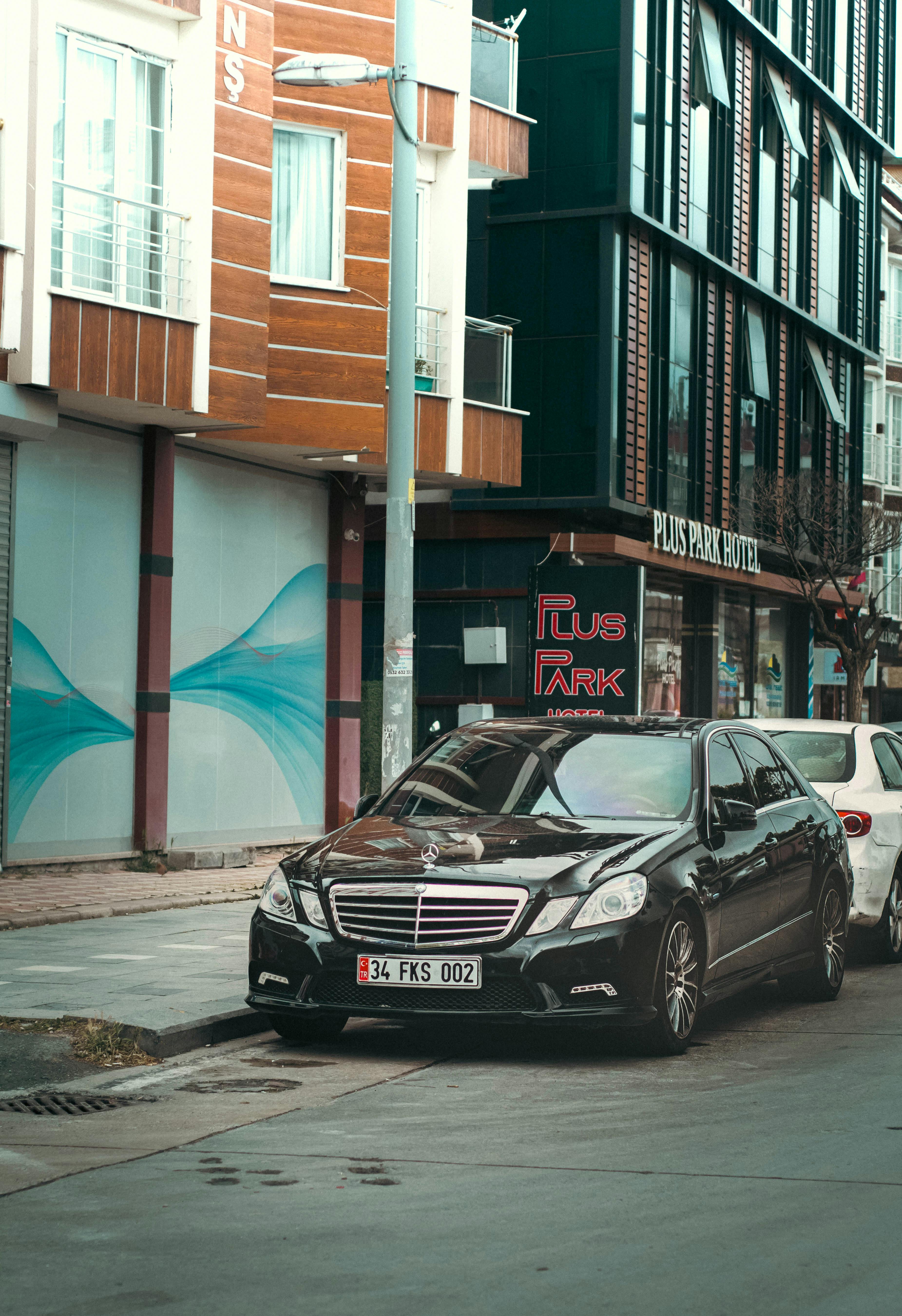 Elegant Black Car Parked in Urban City Street · Free Stock Photo