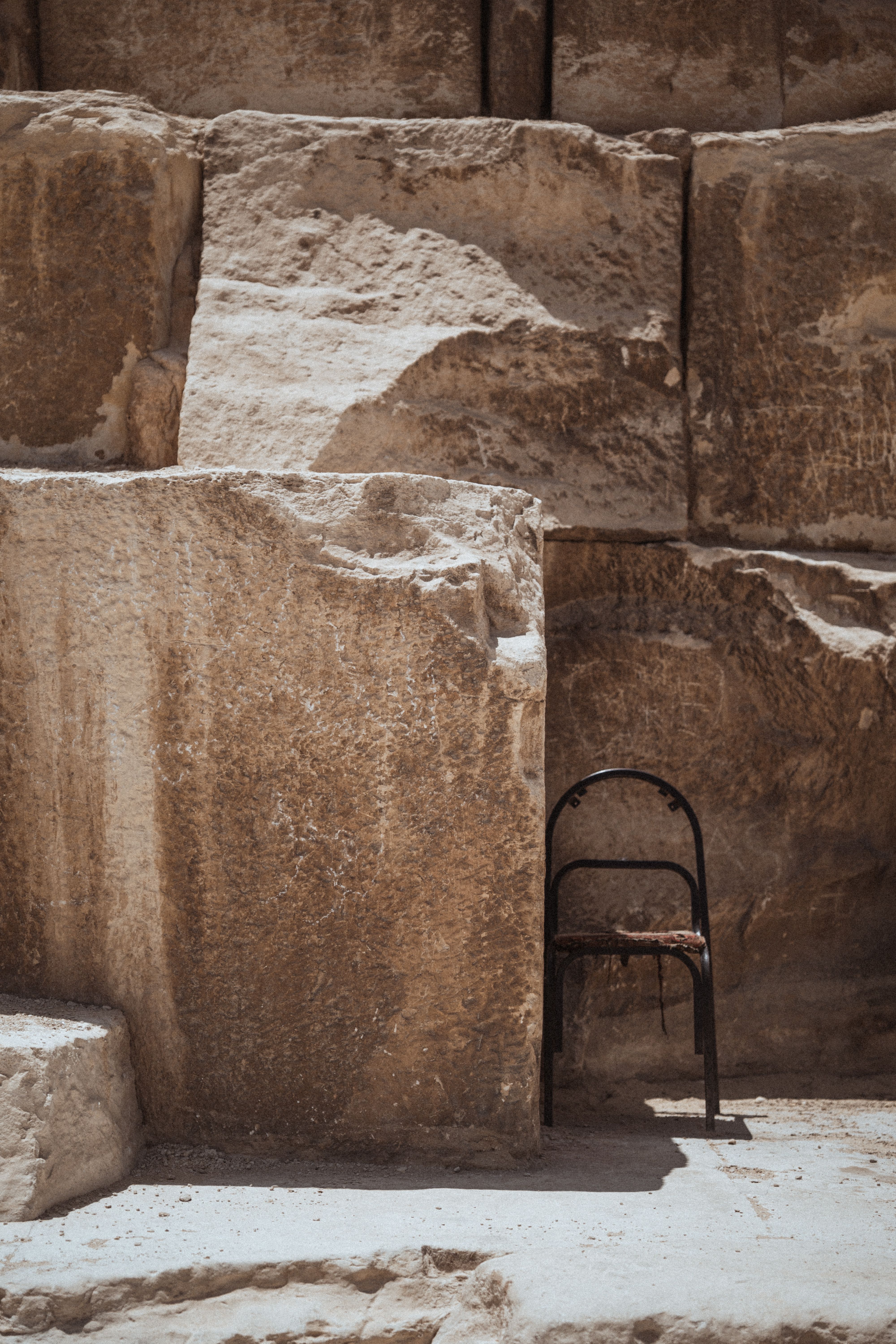 Solitary Chair by Ancient Stone Wall in Daylight · Free Stock Photo