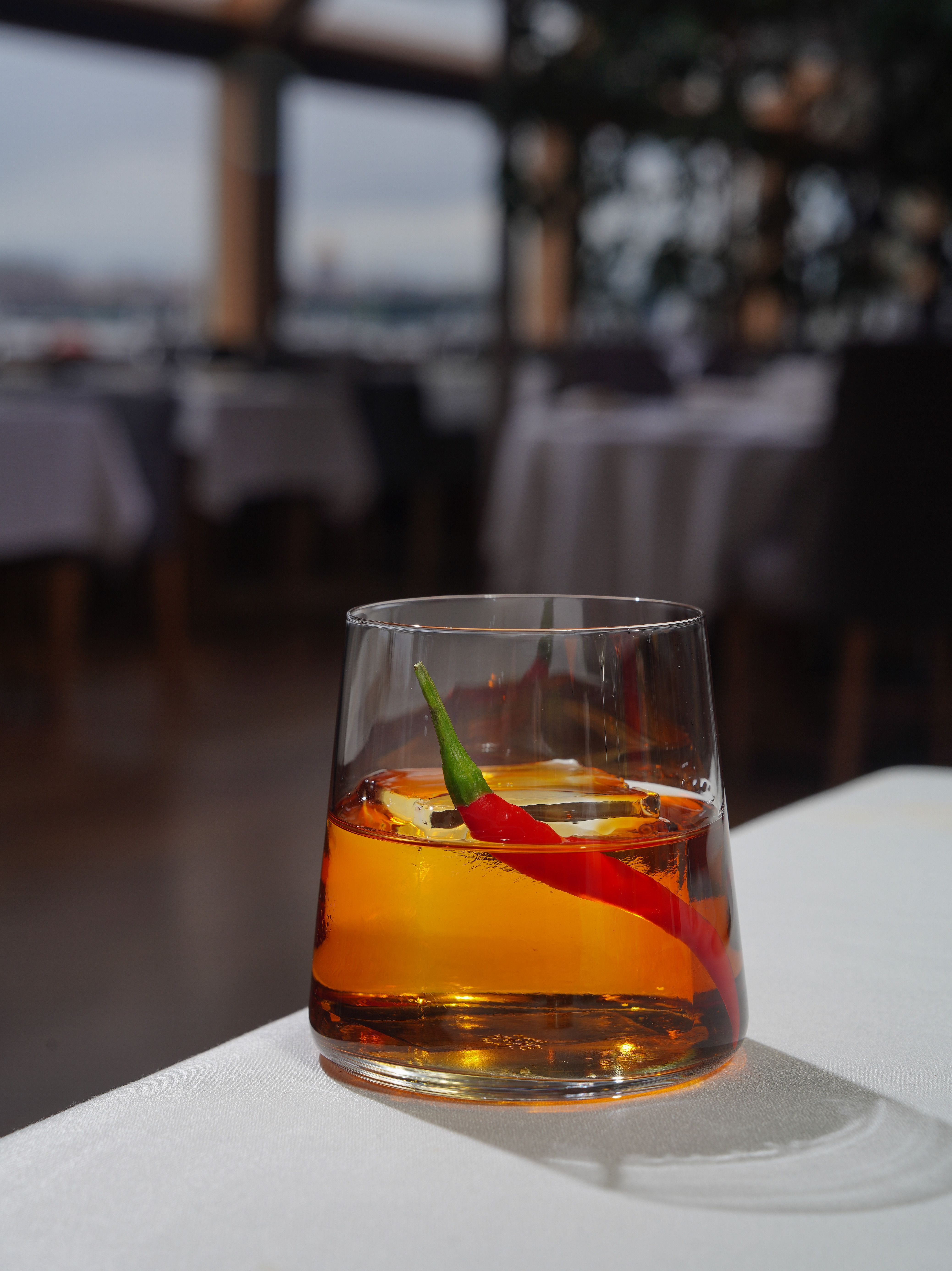 Chili-Infused Cocktail in Sunlit Restaurant · Free Stock Photo