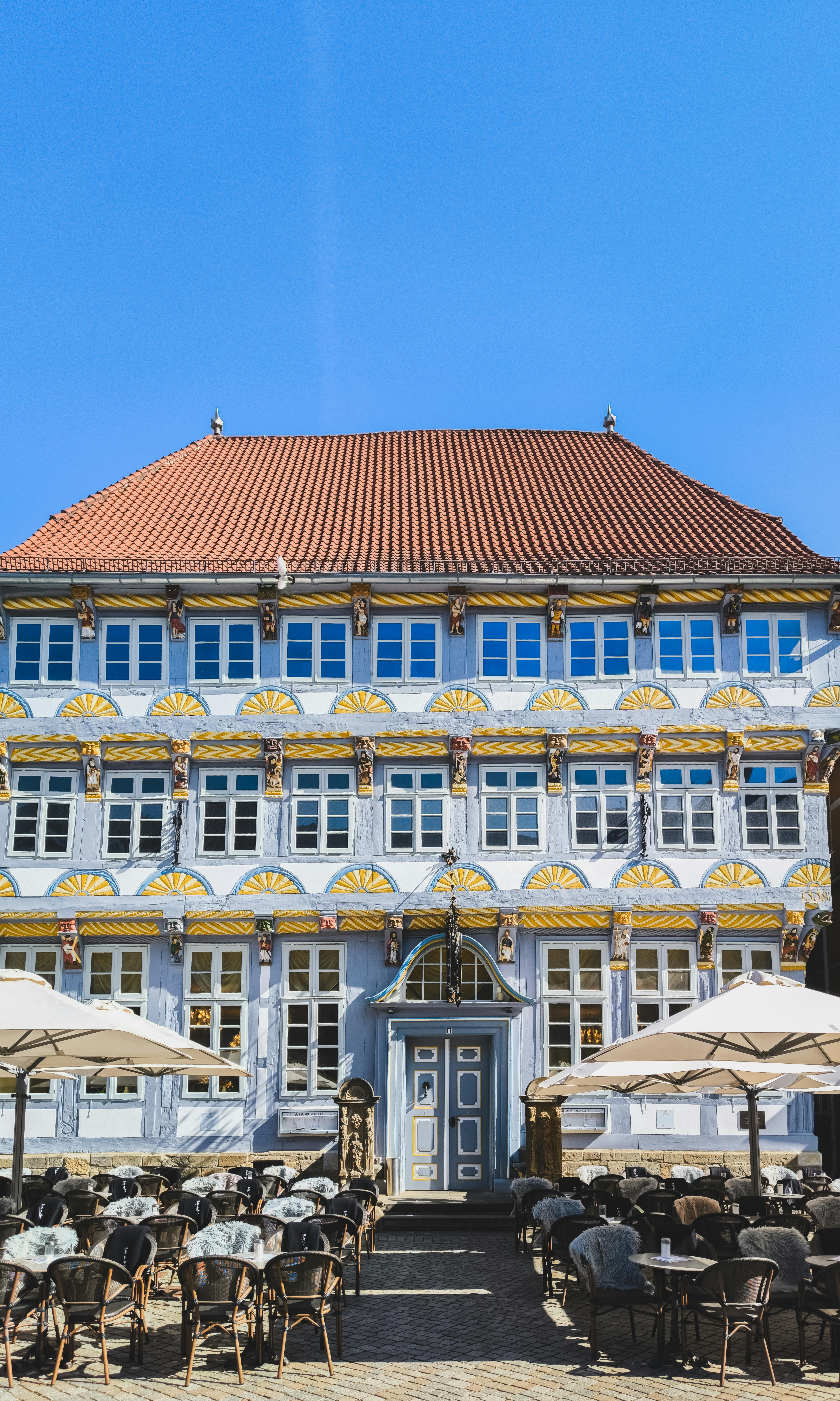 Historic German Building with Outdoor Cafe Seating · Free Stock Photo