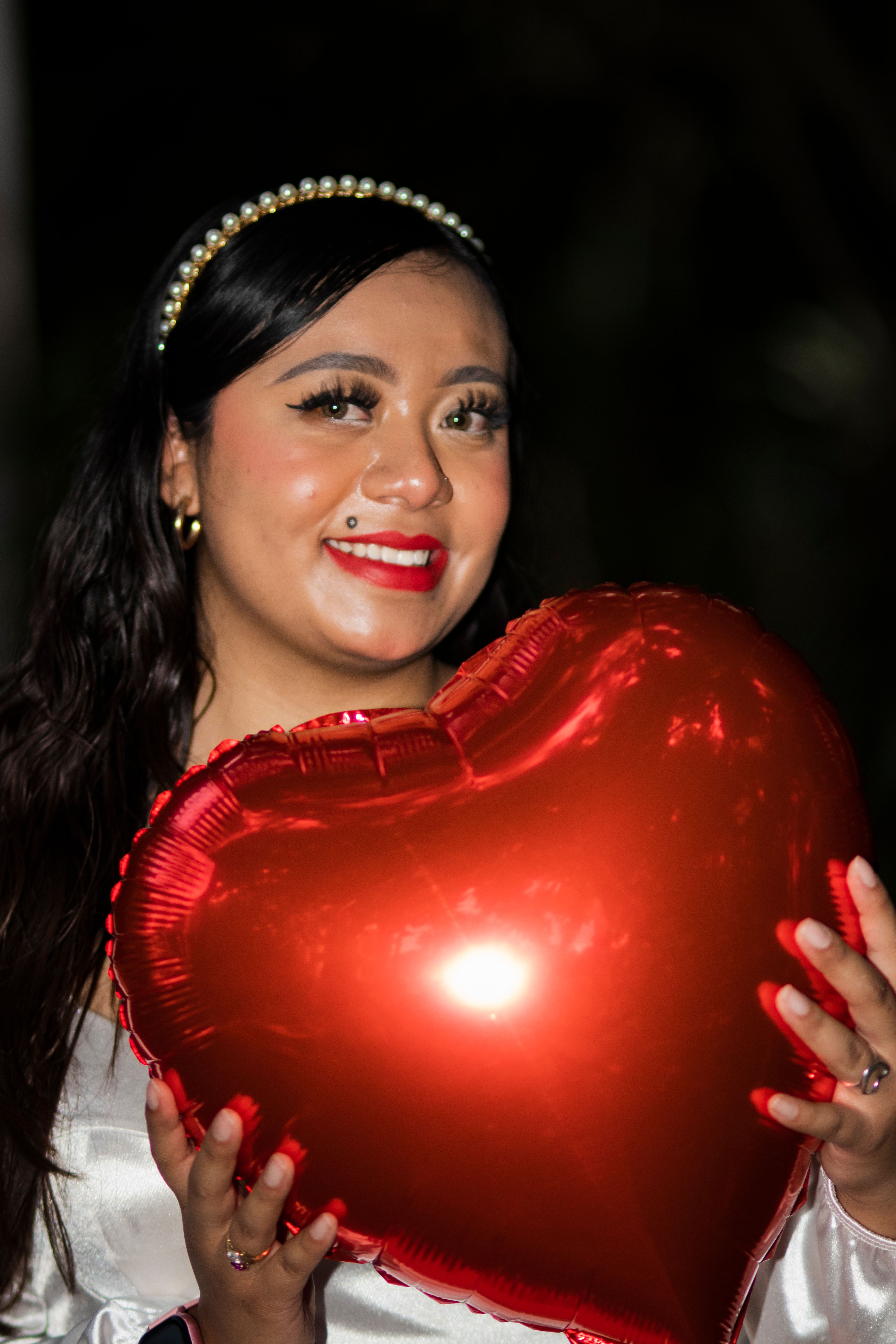 Mujer Sonriente Sosteniendo Un Globo En Forma De Corazón Foto De