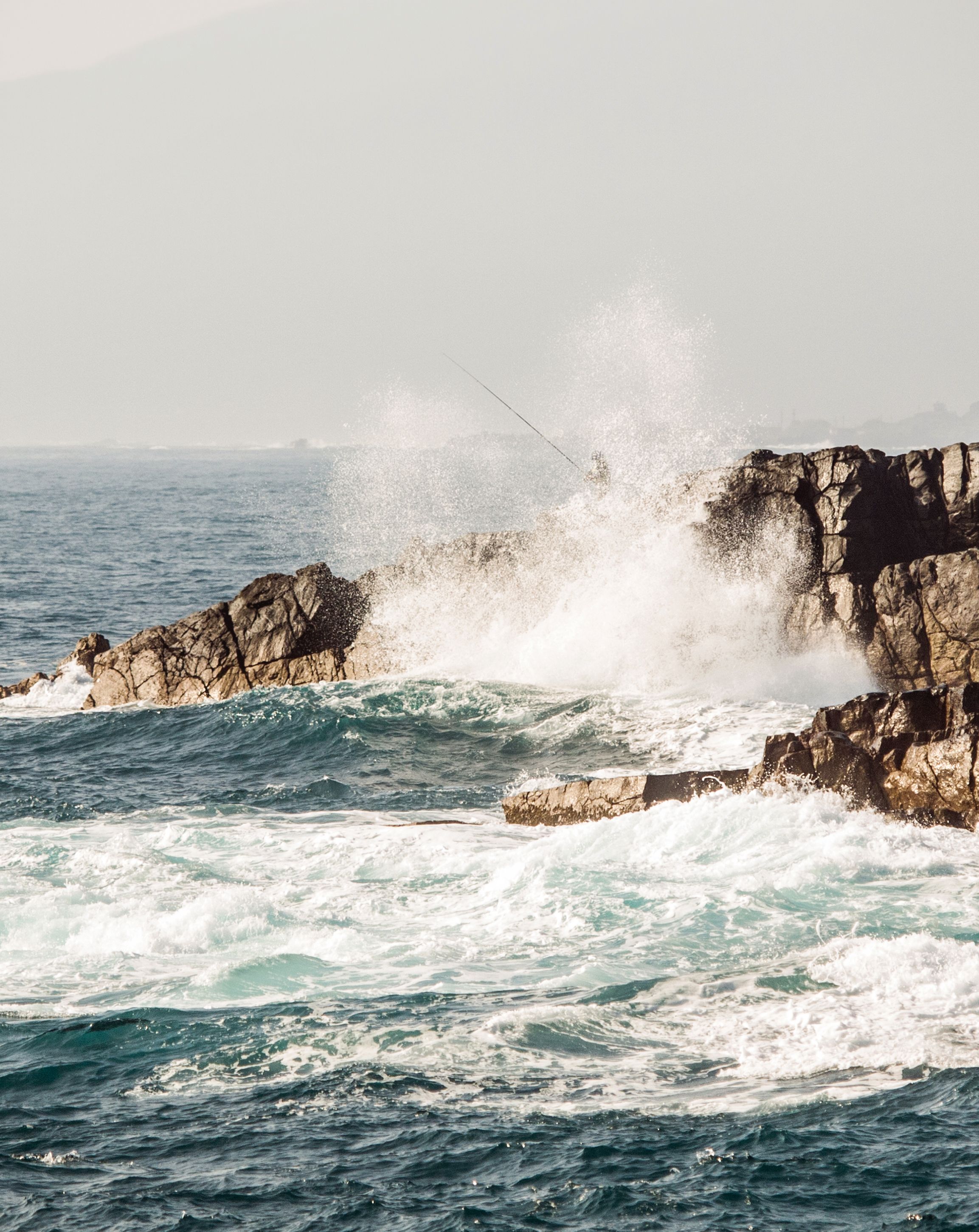 Dramatic Coastal Fishing at Rocky Shoreline · Free Stock Photo