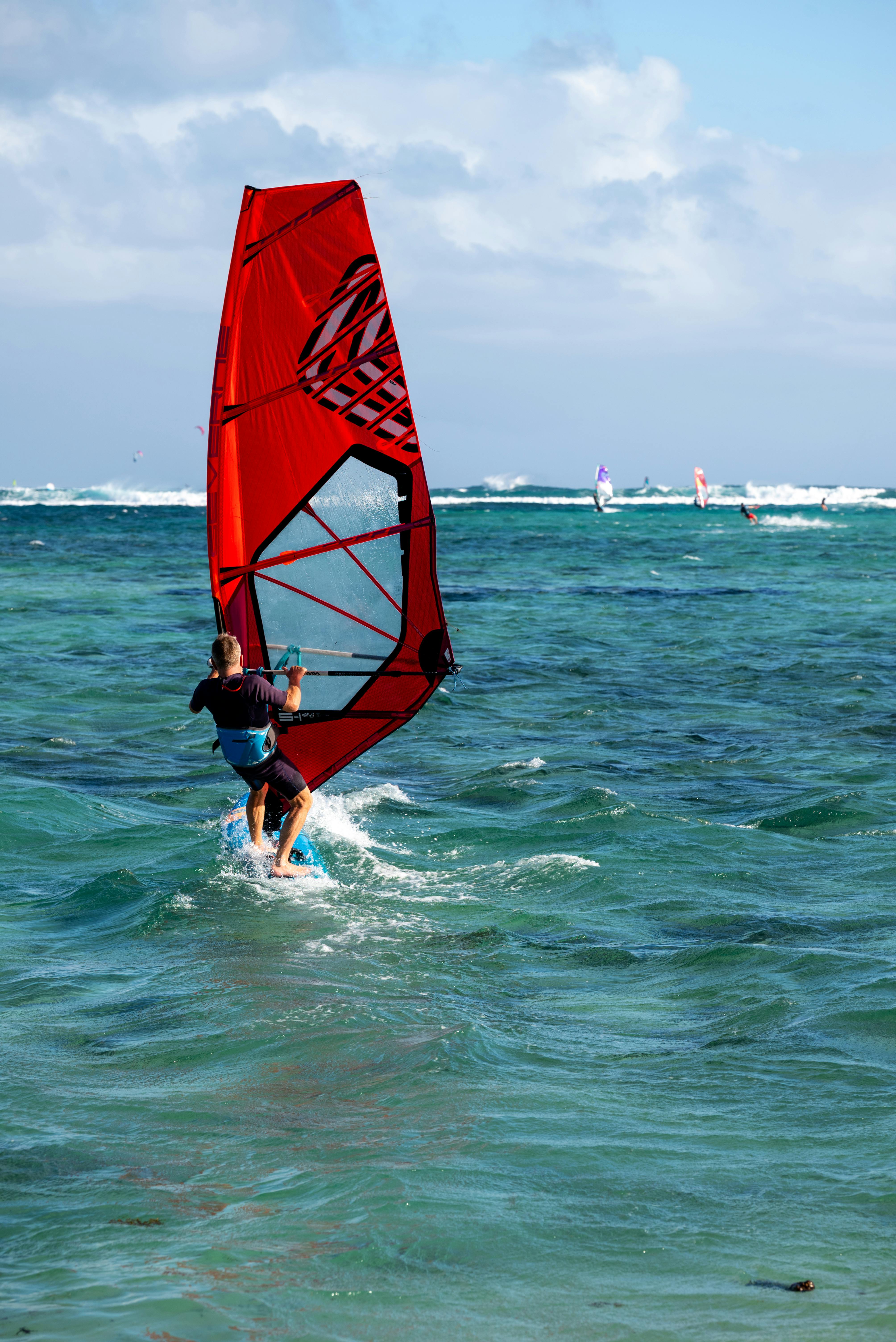 Windsurfer Gliding on Blue Ocean Waves at Daytime · Free Stock Photo