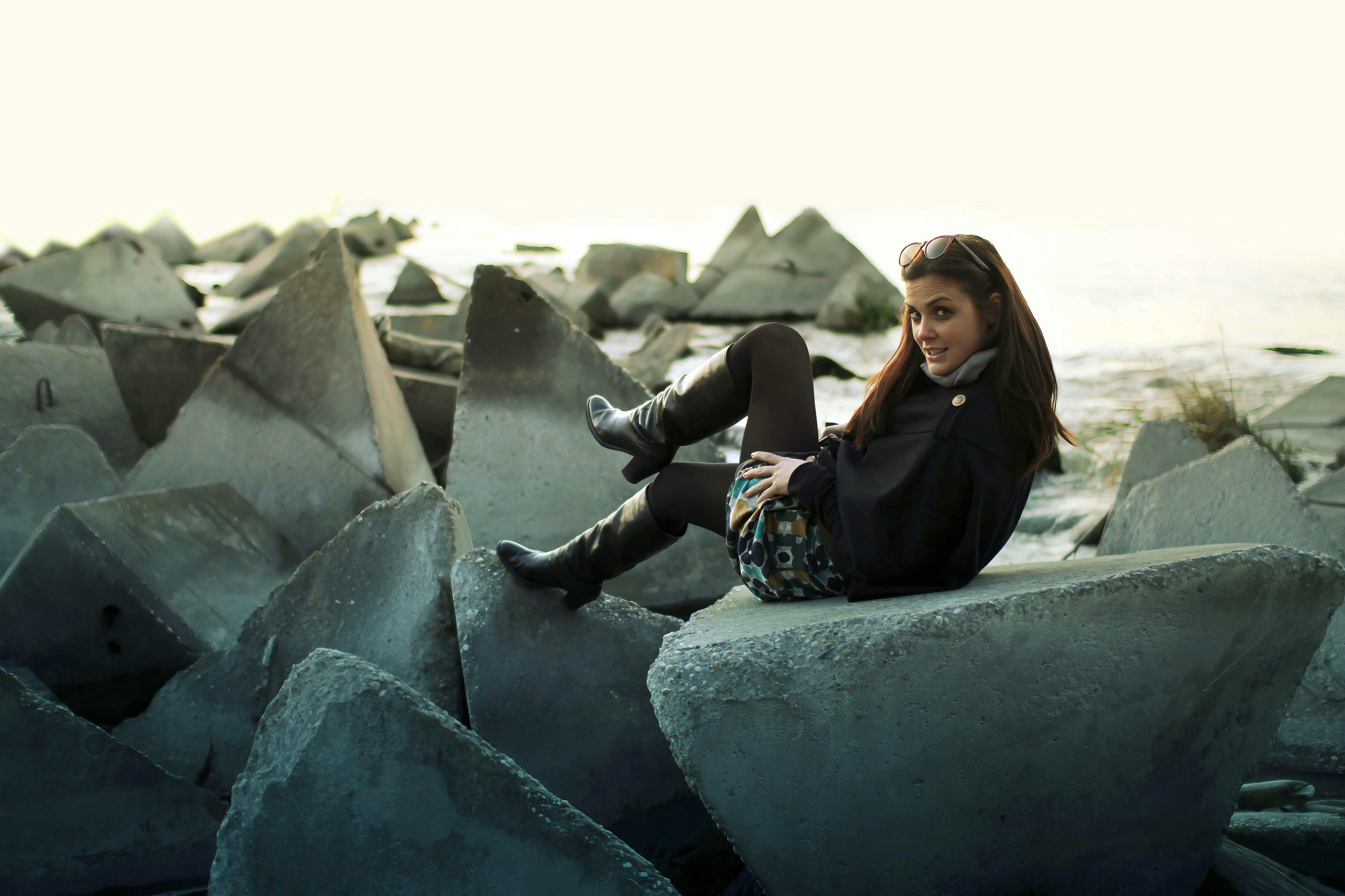 Stylish Woman Posing on Coastal Concrete Blocks · Free Stock Photo
