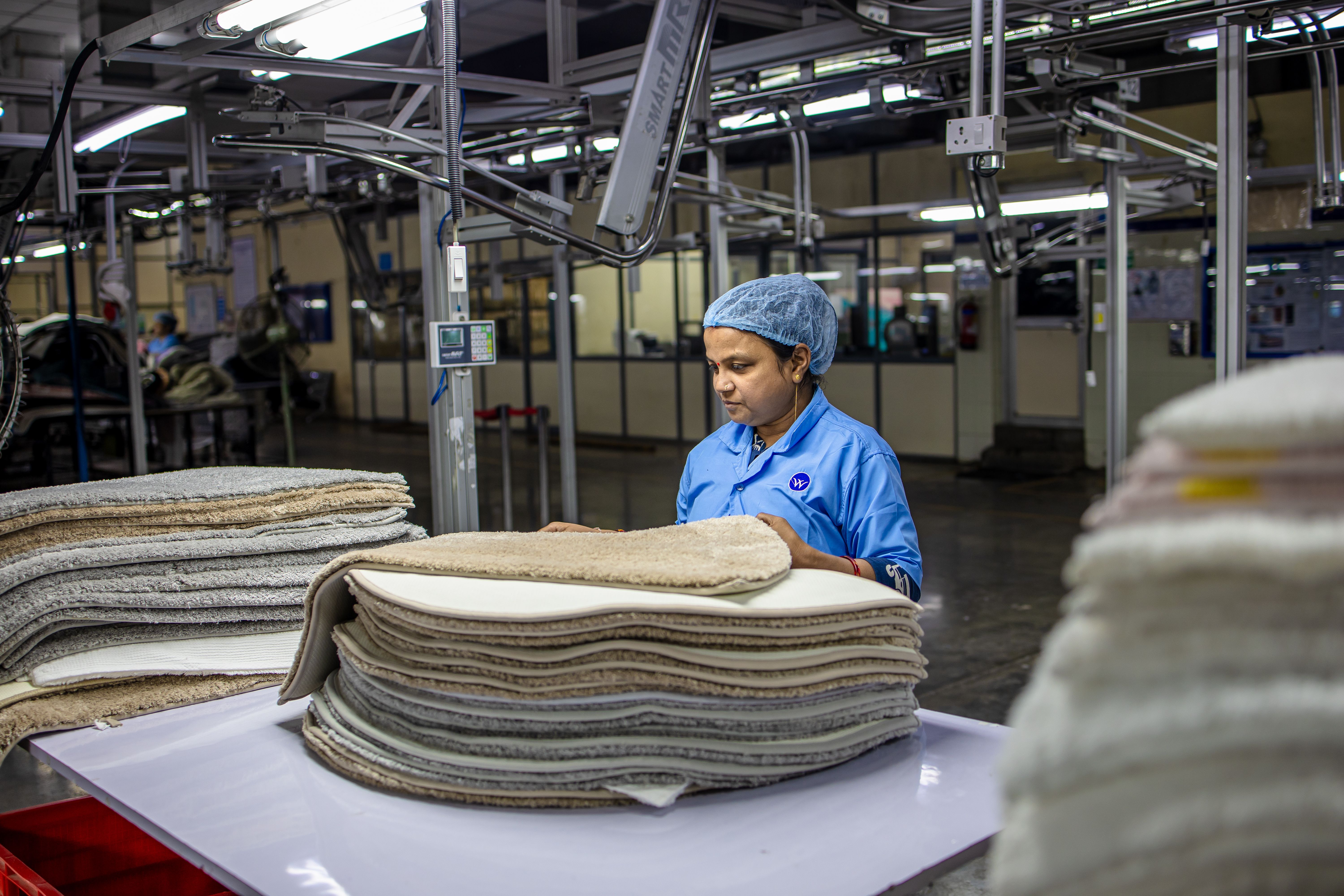 Textile Factory Worker Inspecting Carpets · Free Stock Photo