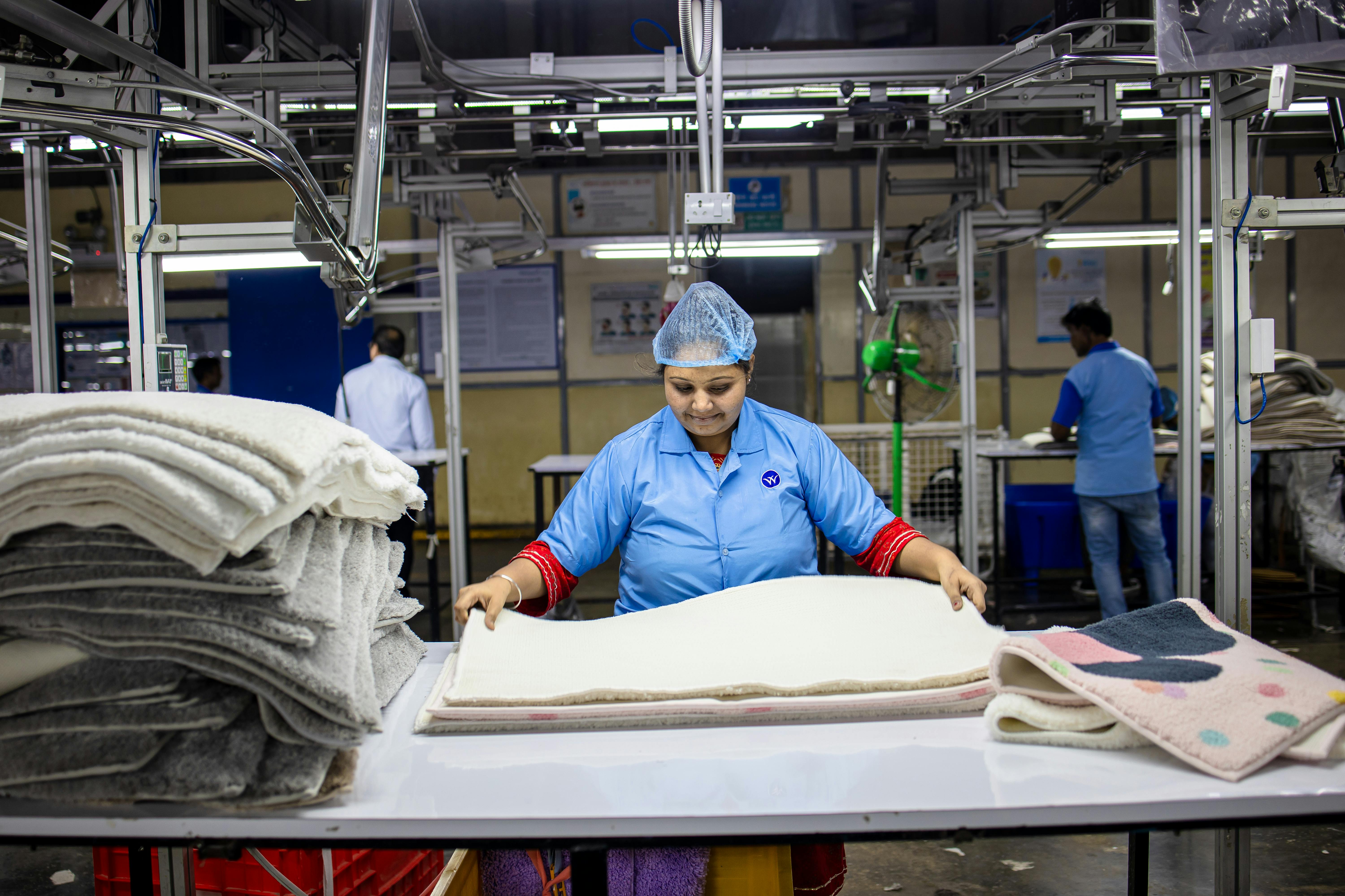Textile Factory Worker Organizing Fabrics · Free Stock Photo