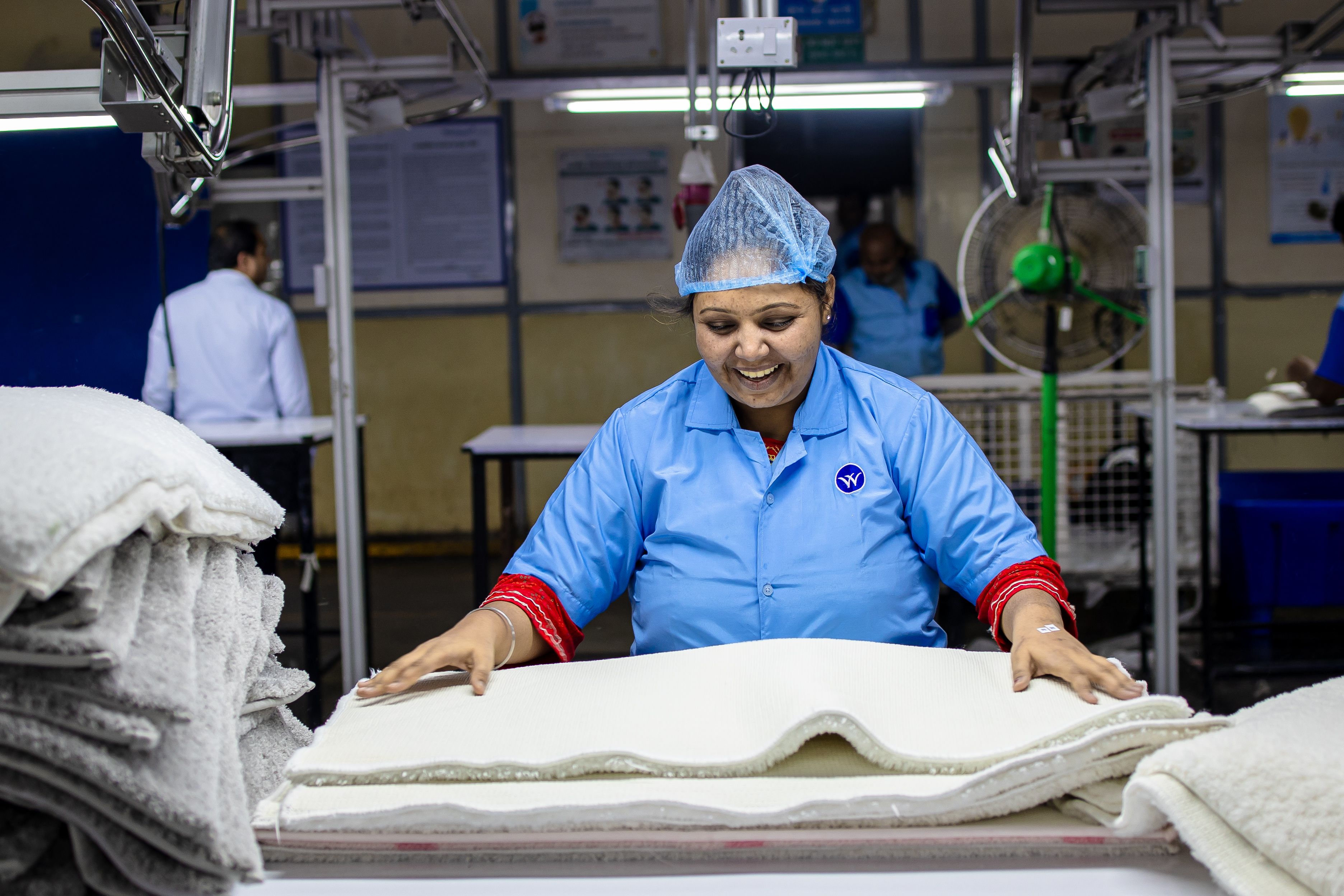 Smiling Textile Worker in Factory Setting · Free Stock Photo