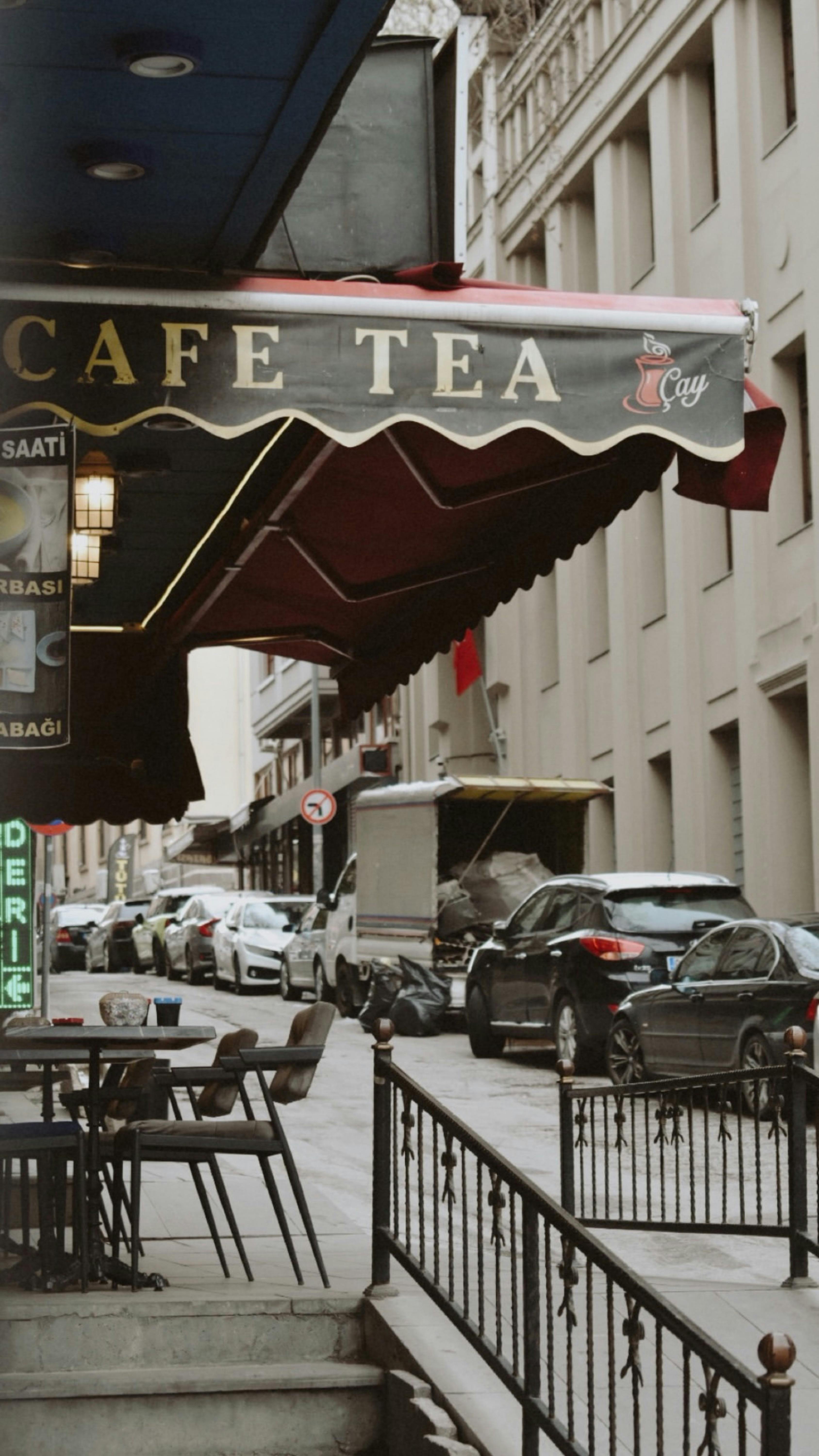 Charming Urban Cafe Street View with Tea Sign · Free Stock Photo