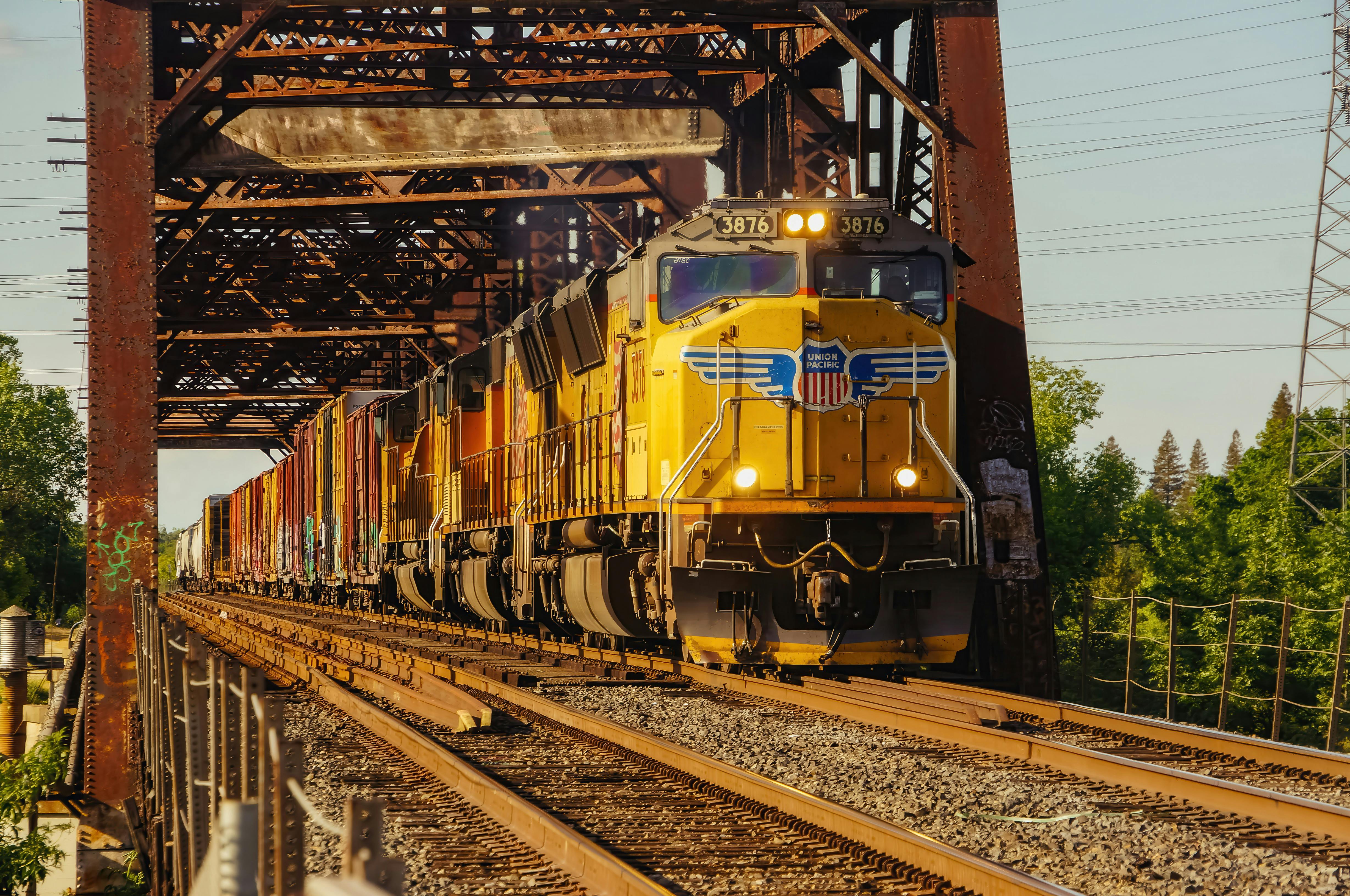 Freight Train Crossing Metal Bridge at Sunset · Free Stock Photo