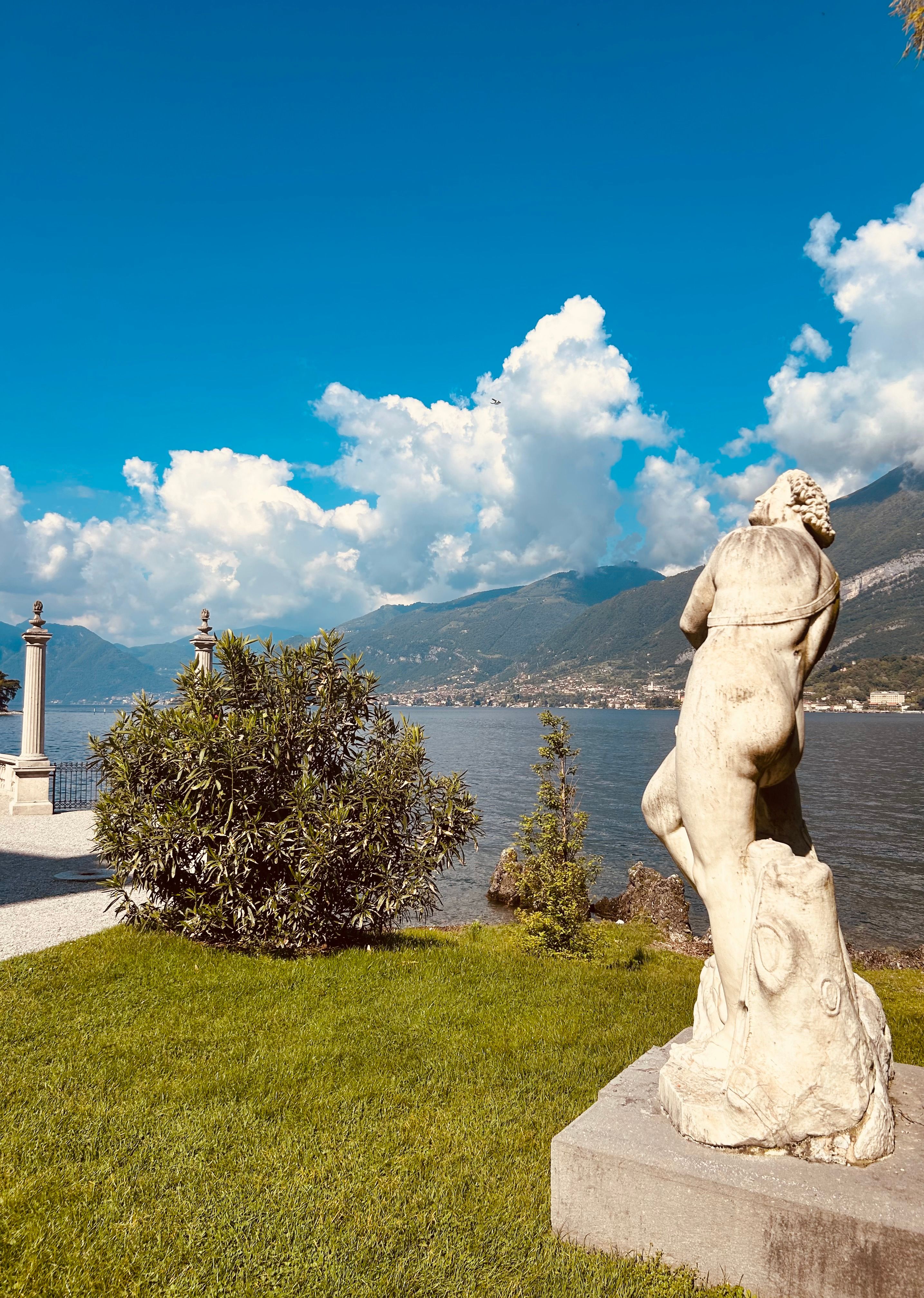 Statue by Scenic Lake Under Blue Sky · Free Stock Photo
