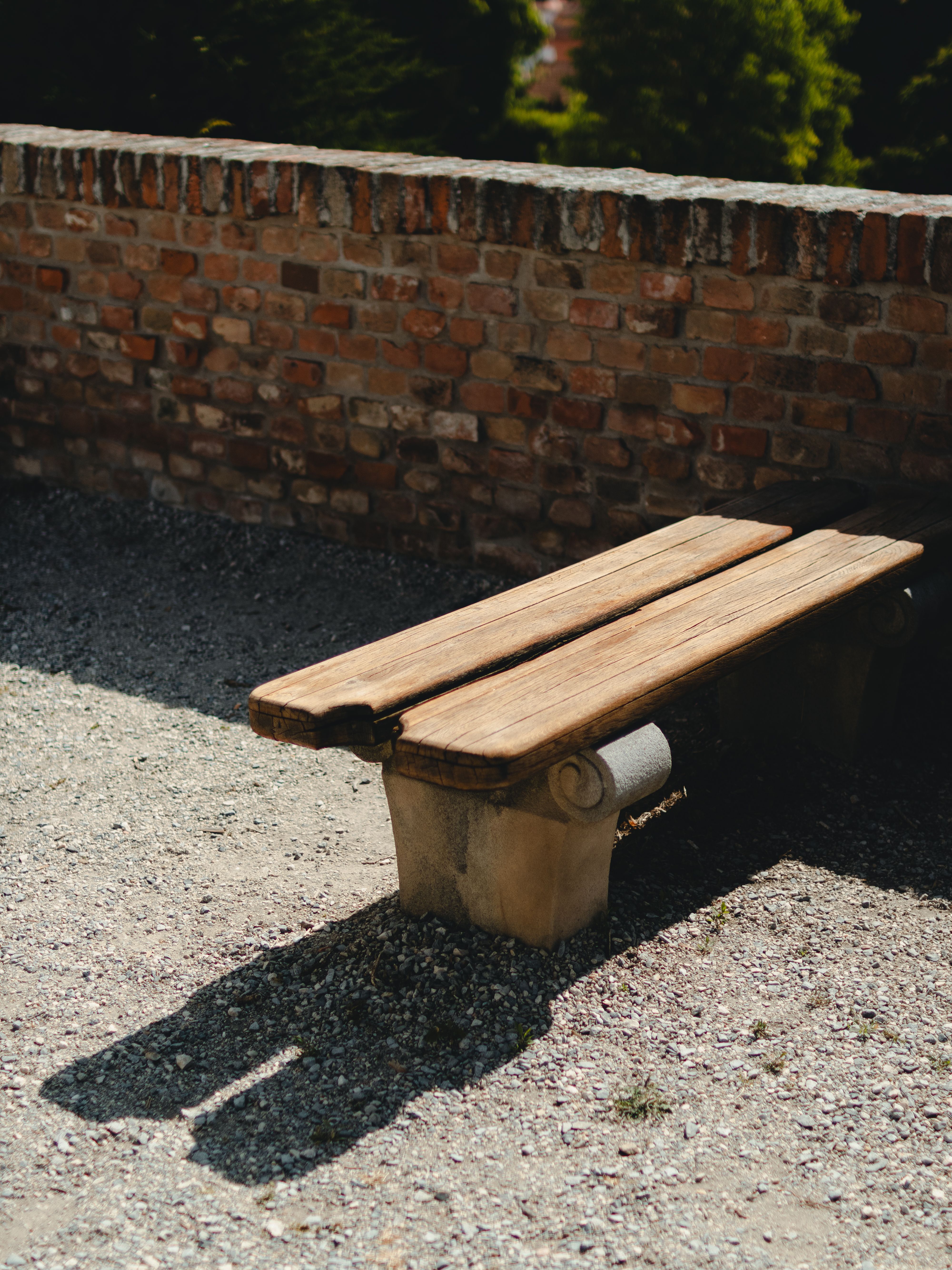 Rustic Wooden Bench Against Brick Wall Outdoors · Free Stock Photo