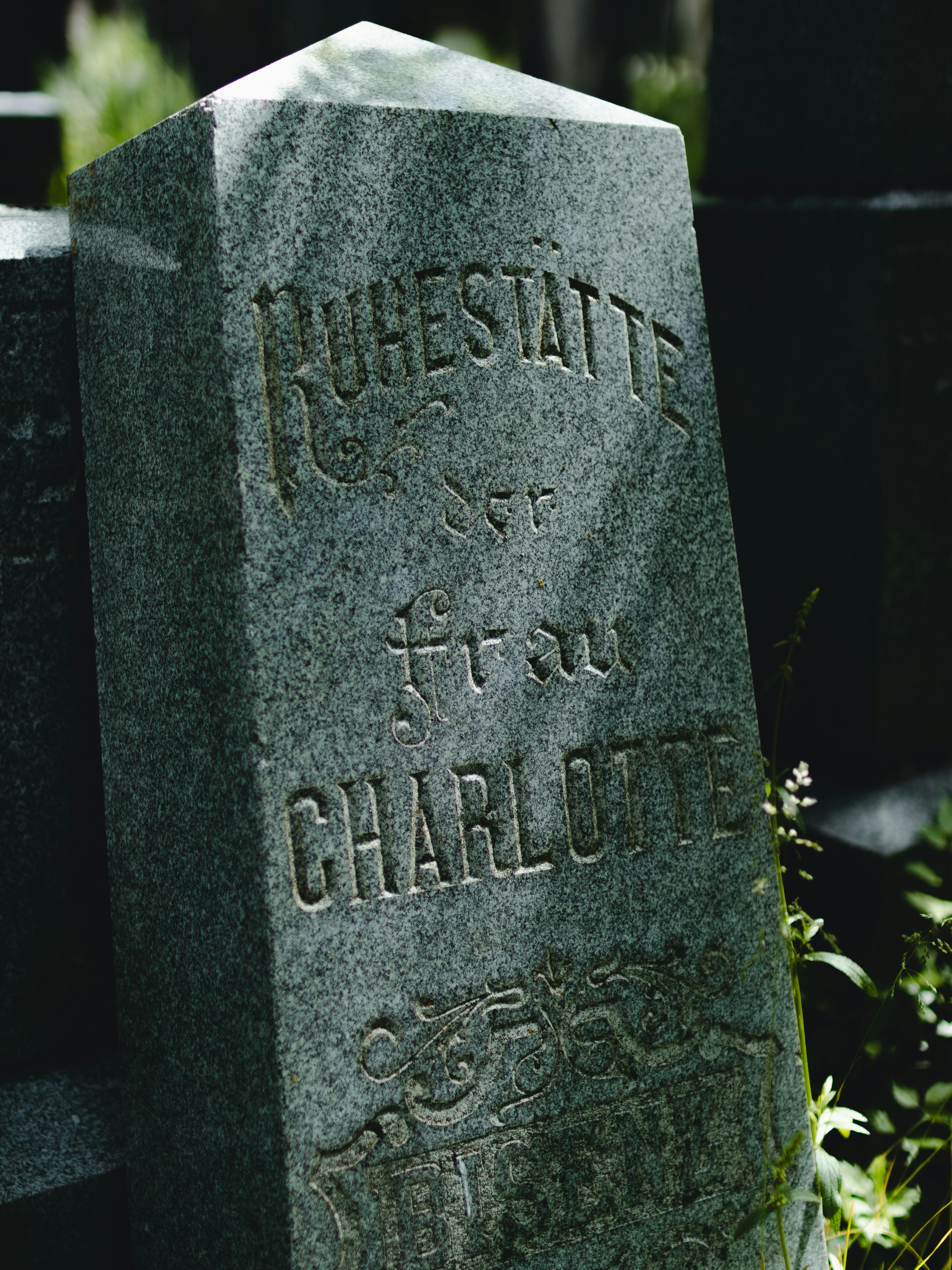 Weathered German Tombstone in Shadowed Cemetery · Free Stock Photo