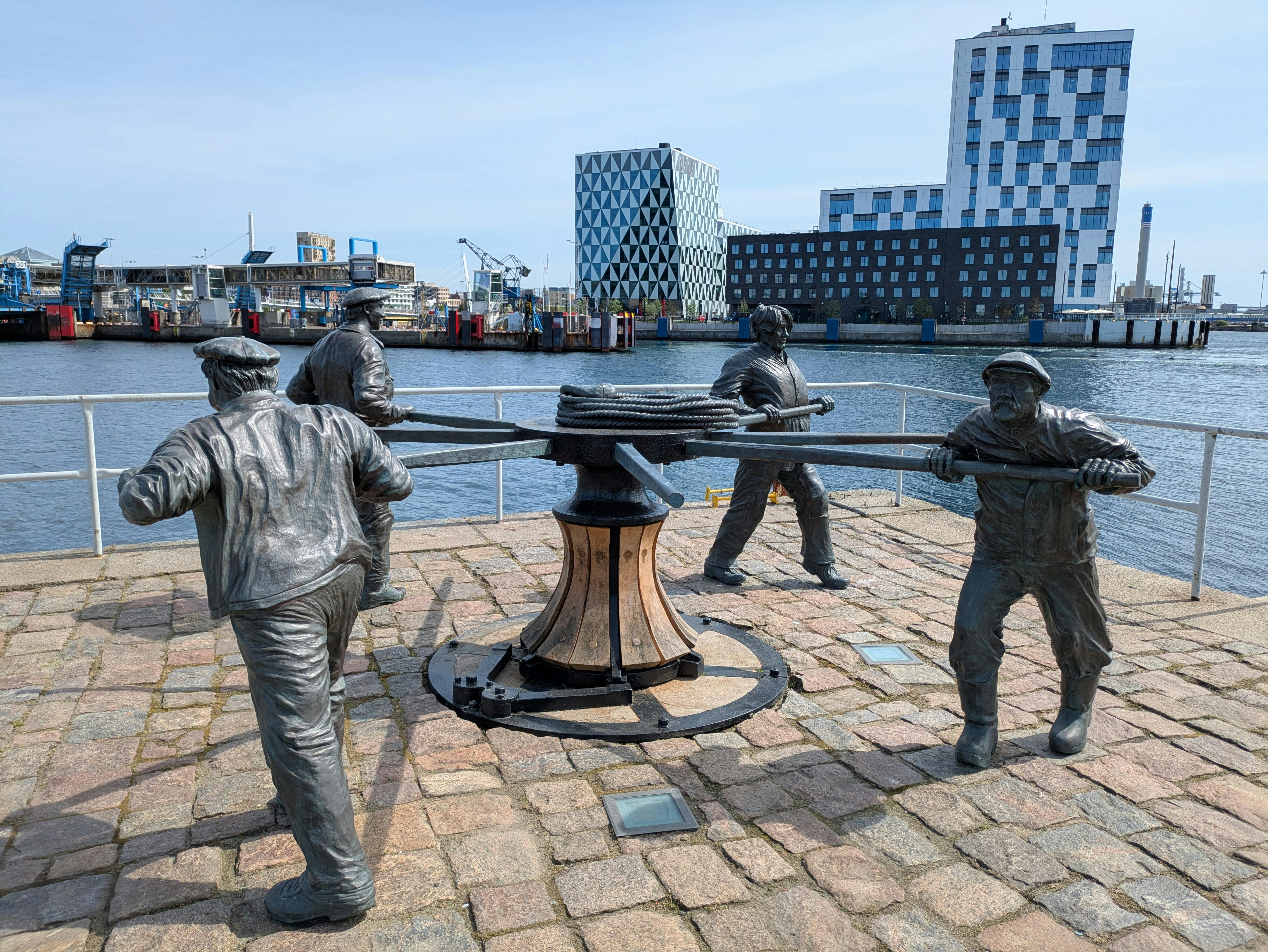 Historic Dockside Statues by Waterfront Buildings · Free Stock Photo