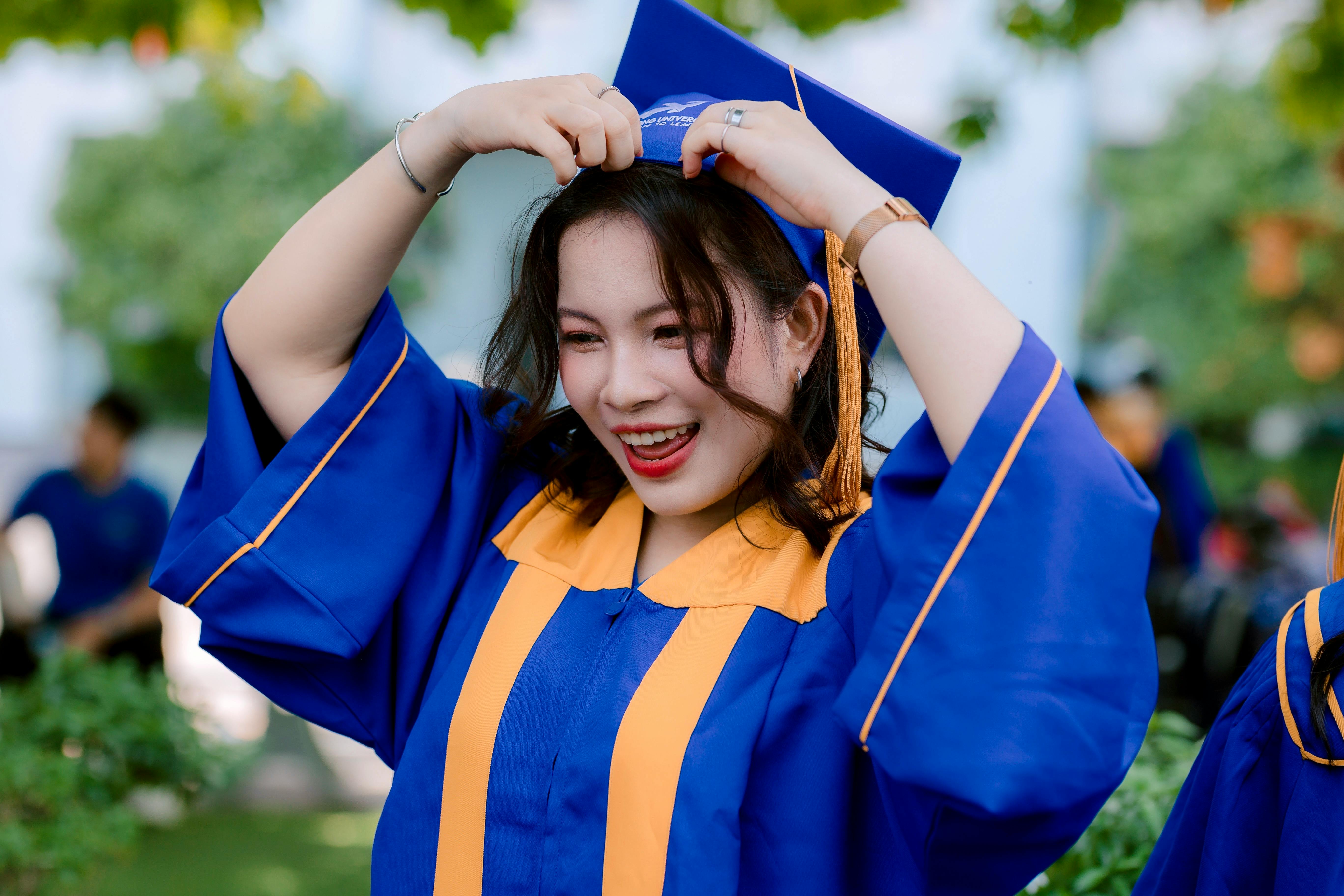 Joyful Graduation Moment in Blue and Gold · Free Stock Photo
