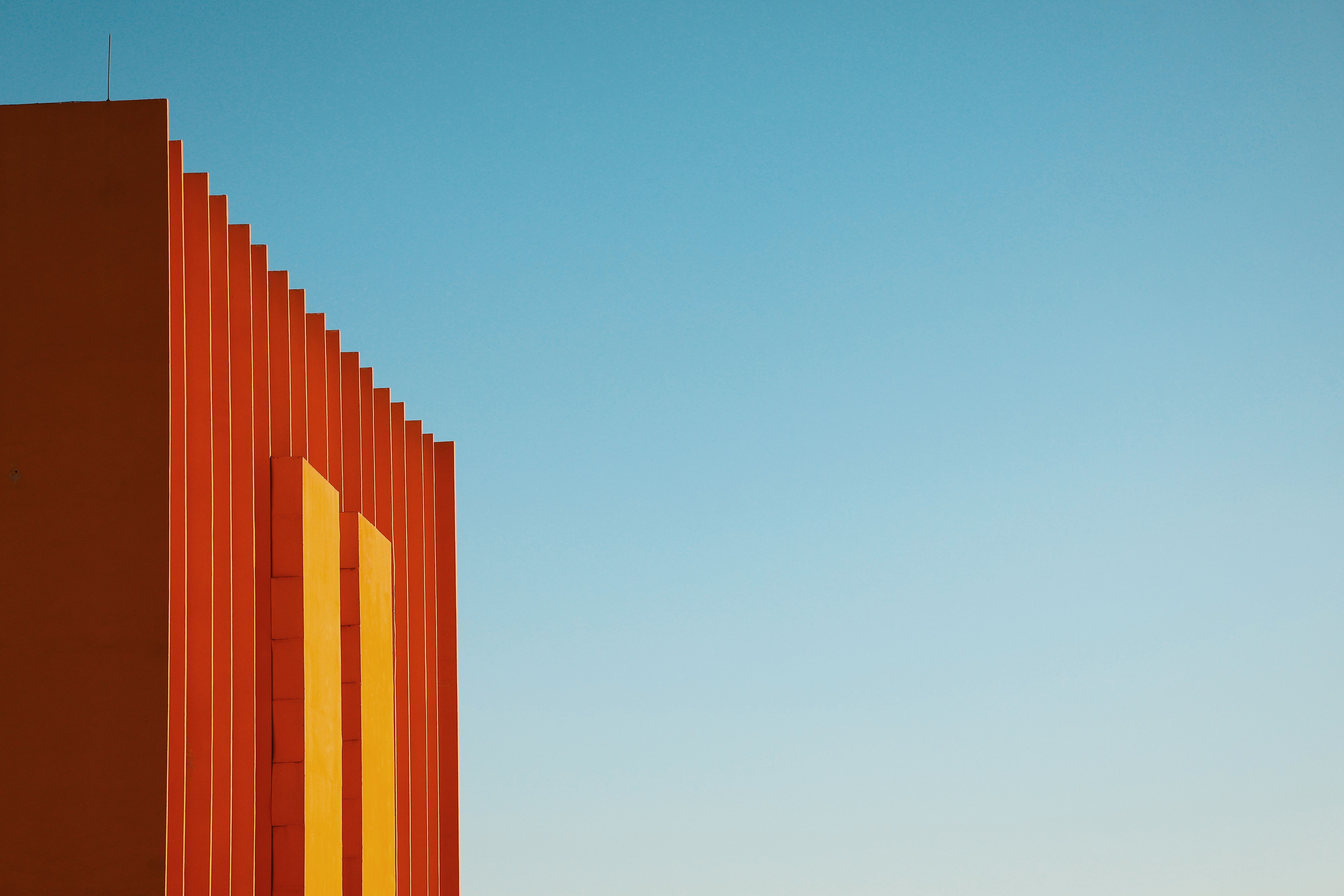Vivid Orange Building Against Clear Blue Sky · Free Stock Photo