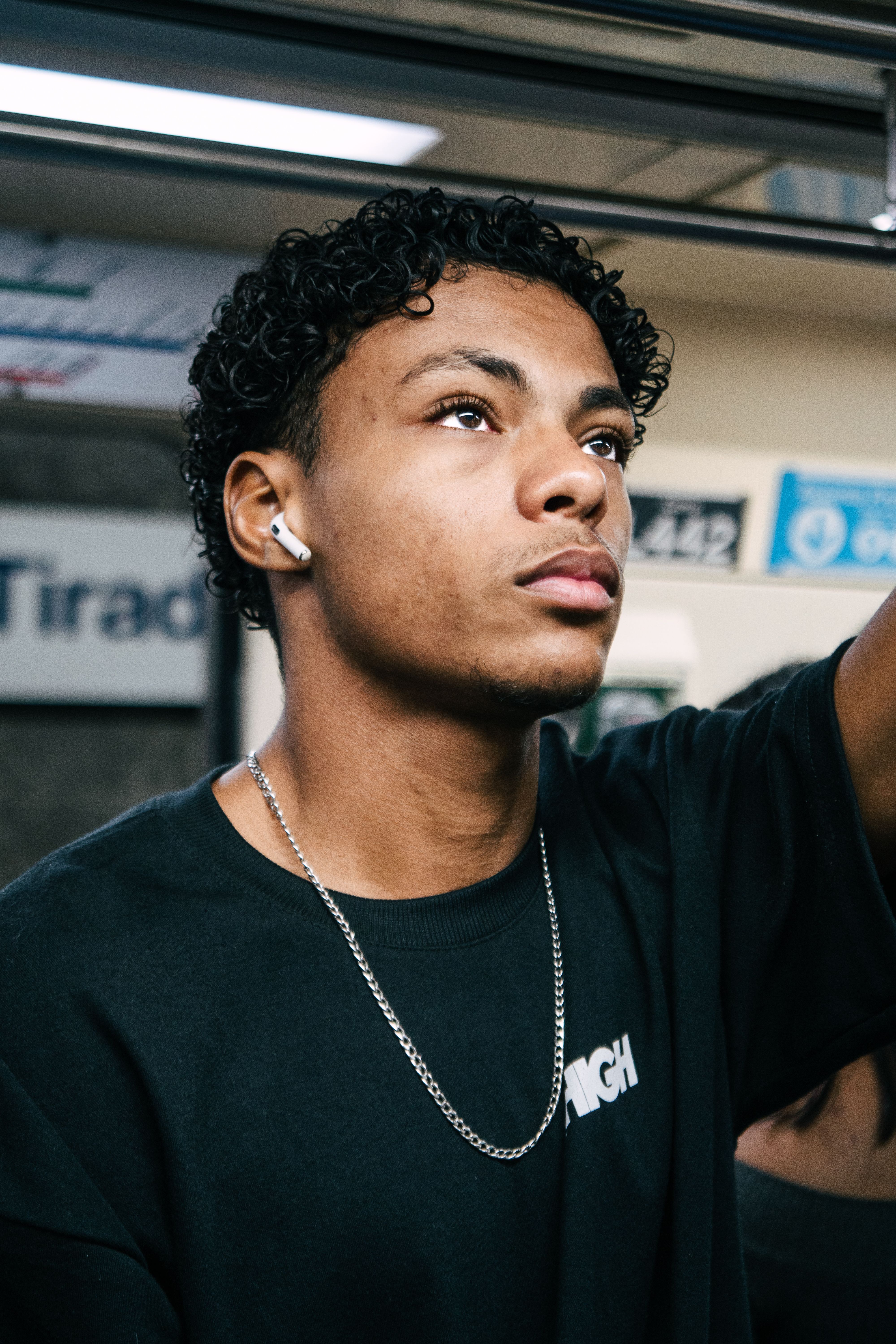 Young Man on Public Transit Wearing Earbuds · Free Stock Photo