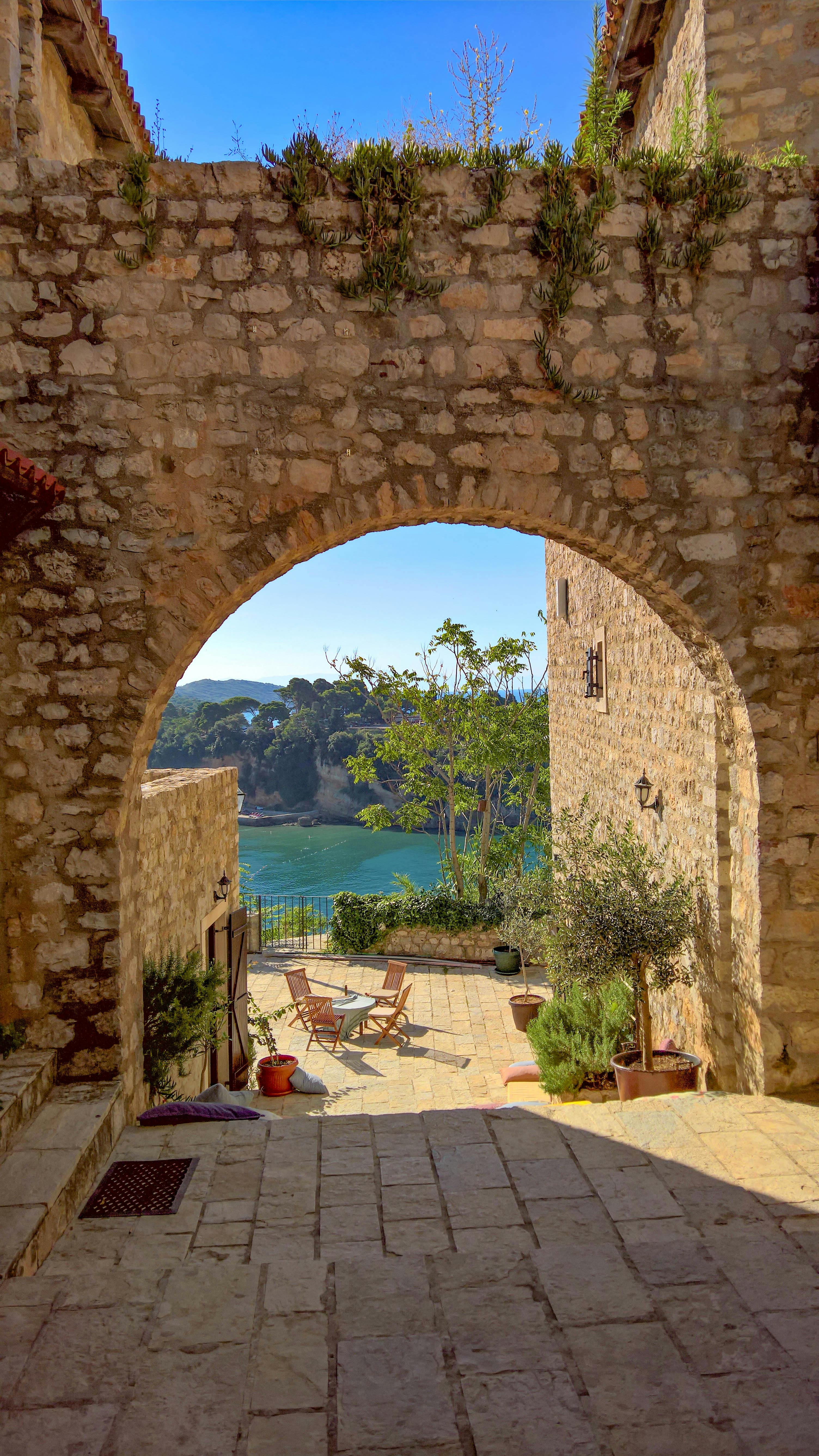 Charming Stone Archway Overlooking Scenic Lagoon · Free Stock Photo