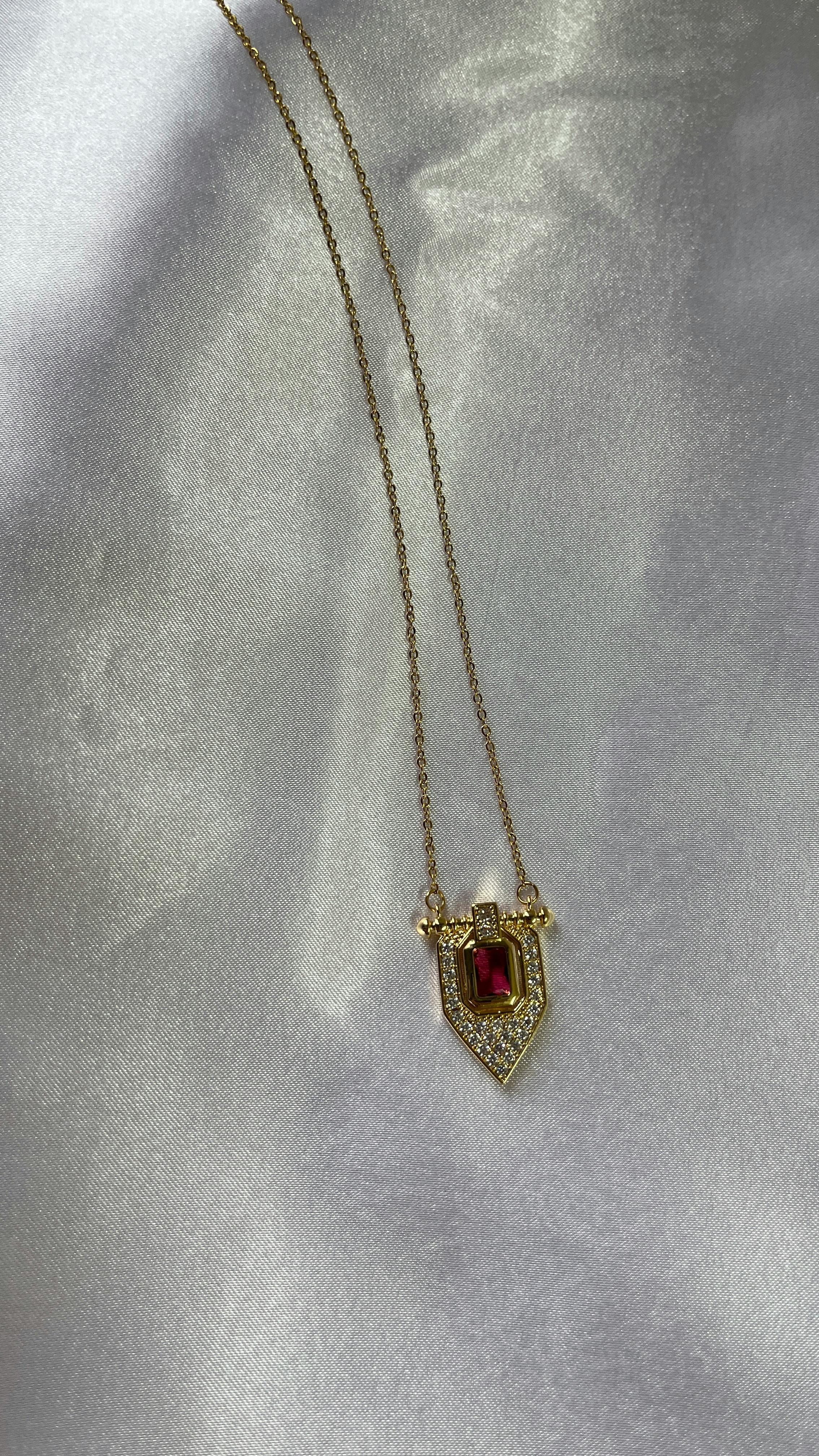Elegant Gold Necklace with Ruby Pendant on Satin · Free Stock Photo