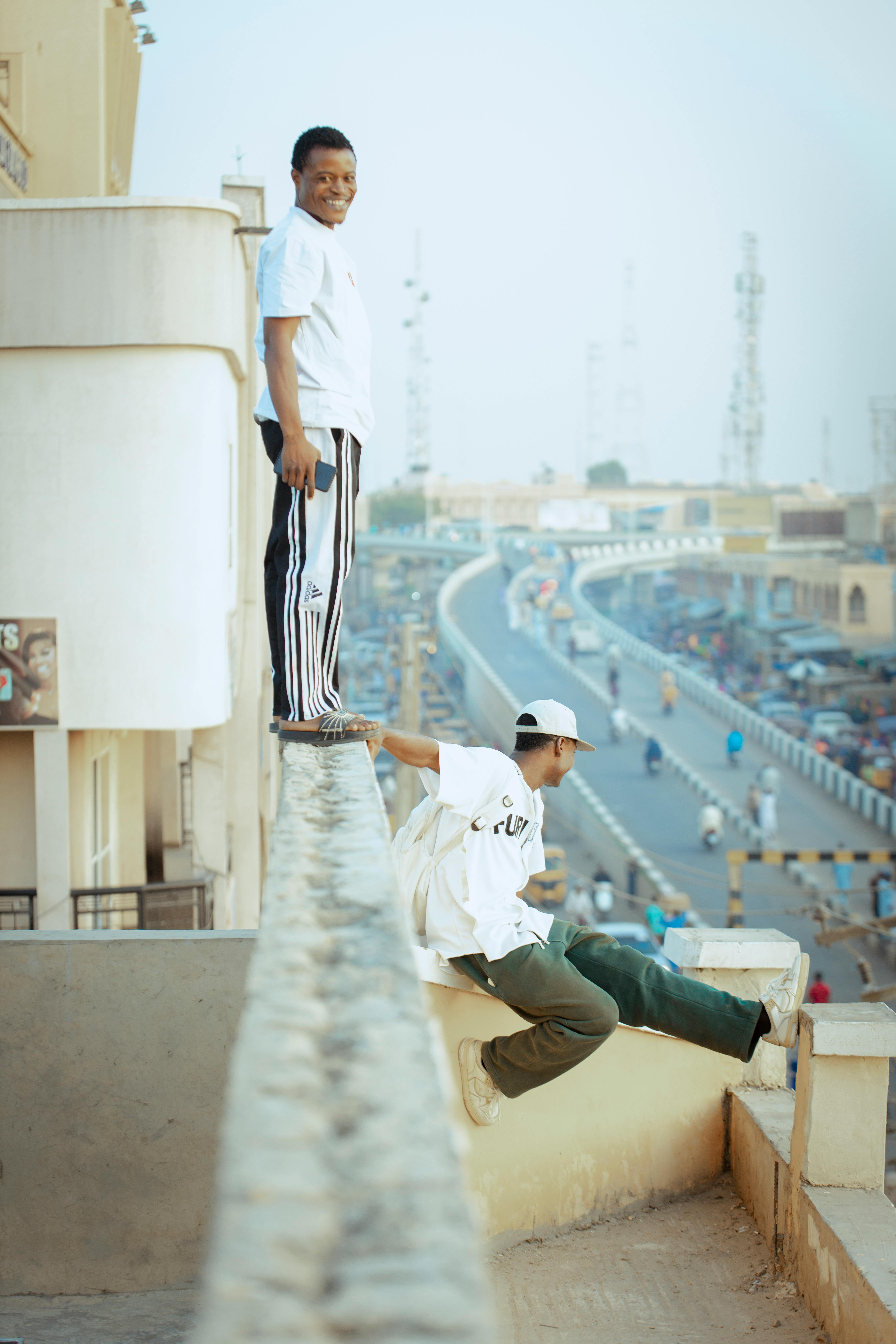 Urban Youth Balancing on Ledge in Cityscape · Free Stock Photo