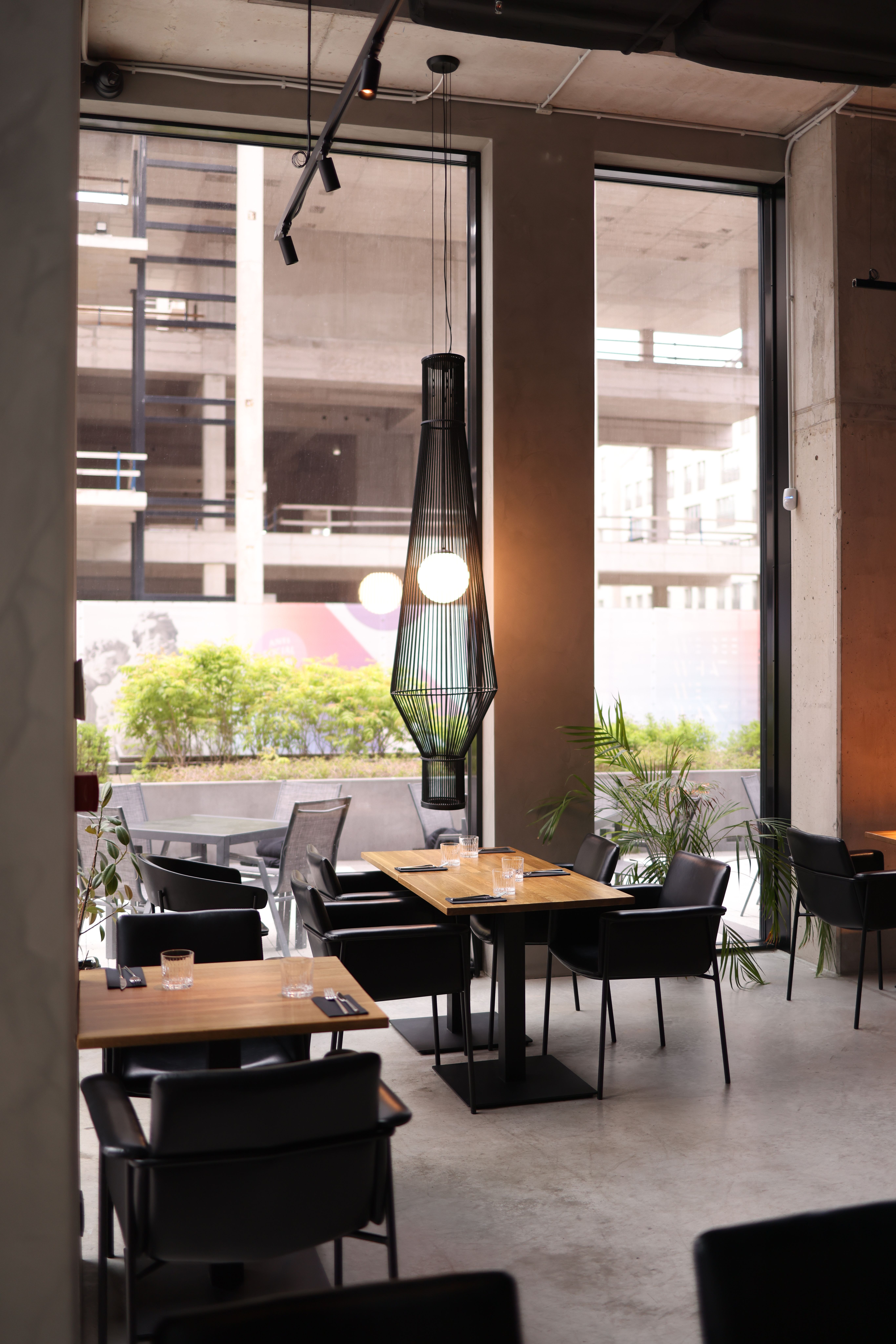 Modern Urban Cafe Interior with Large Windows · Free Stock Photo