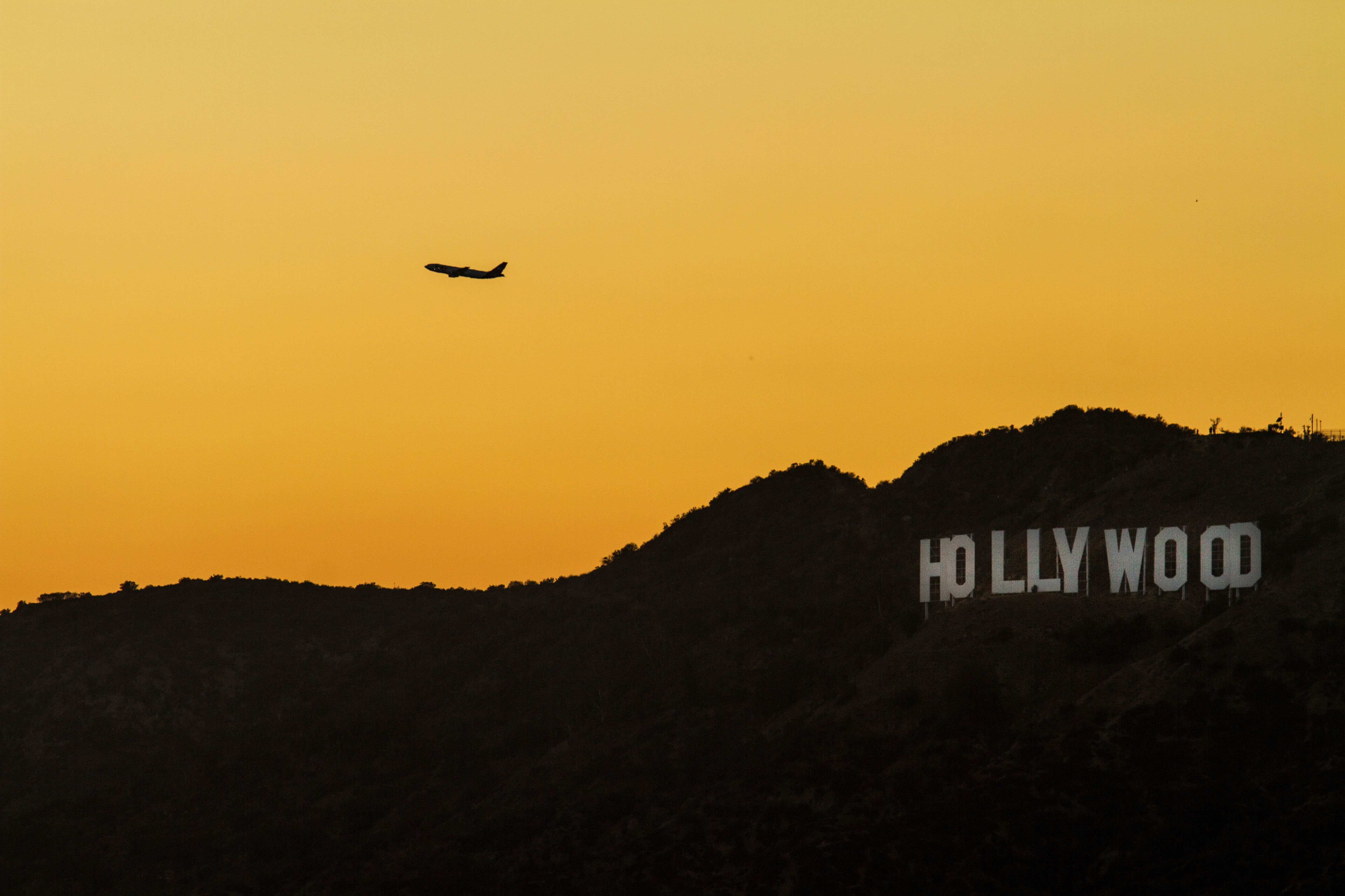 Airplane over Hollywood Sign at Sunset · Free Stock Photo