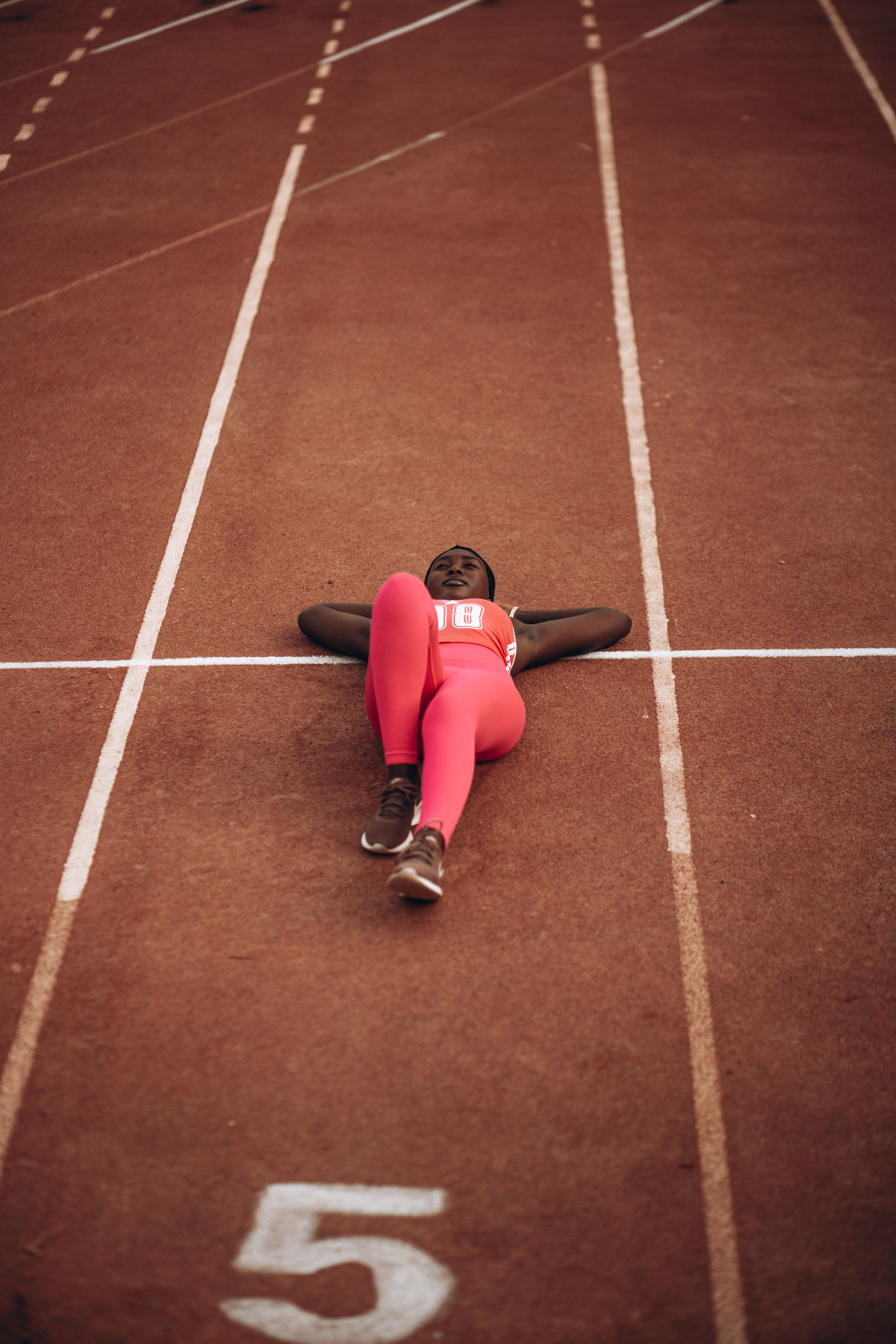 Athlete Relaxing on Track After Race · Free Stock Photo
