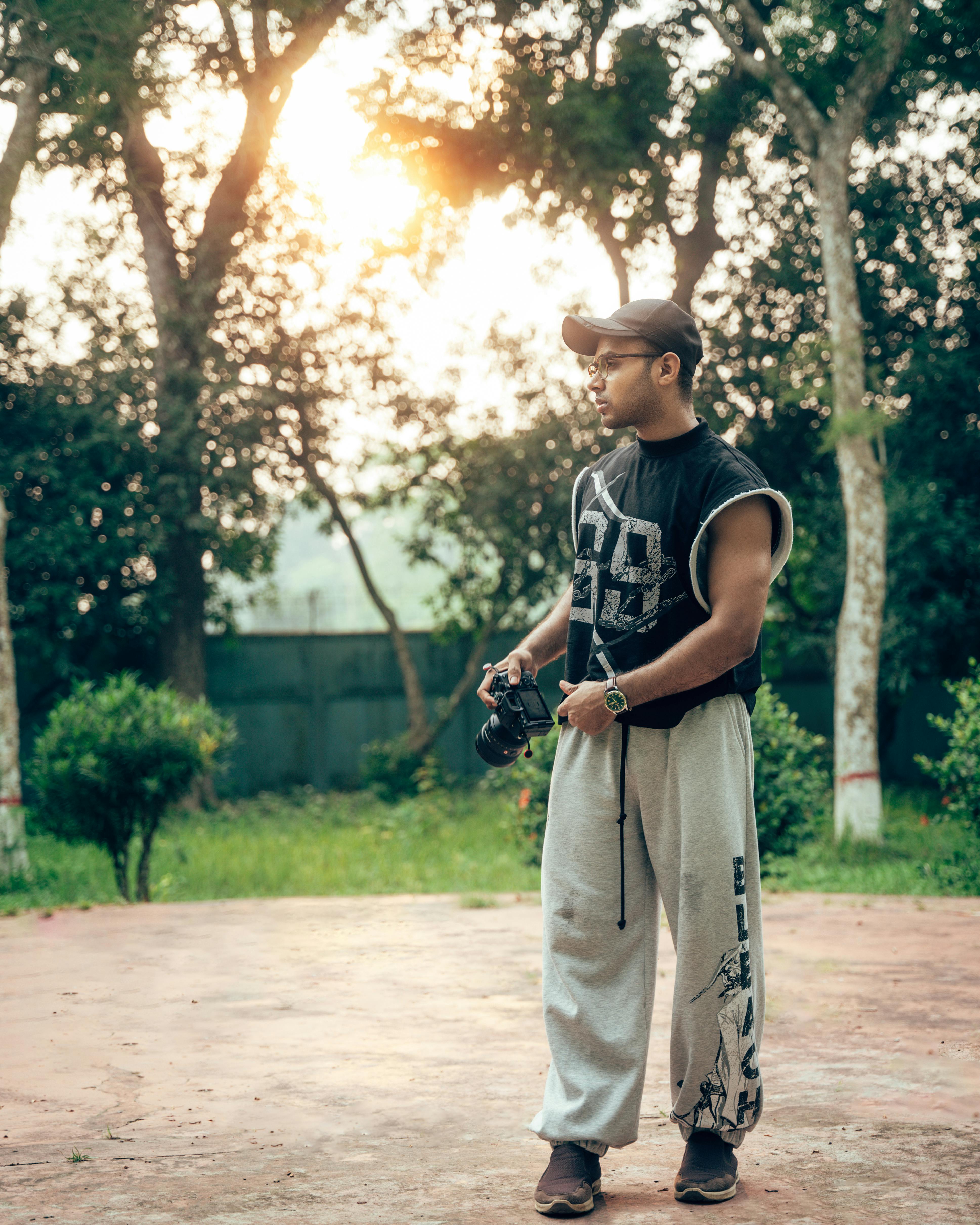 Young Man with Camera in Outdoor Park Setting · Free Stock Photo