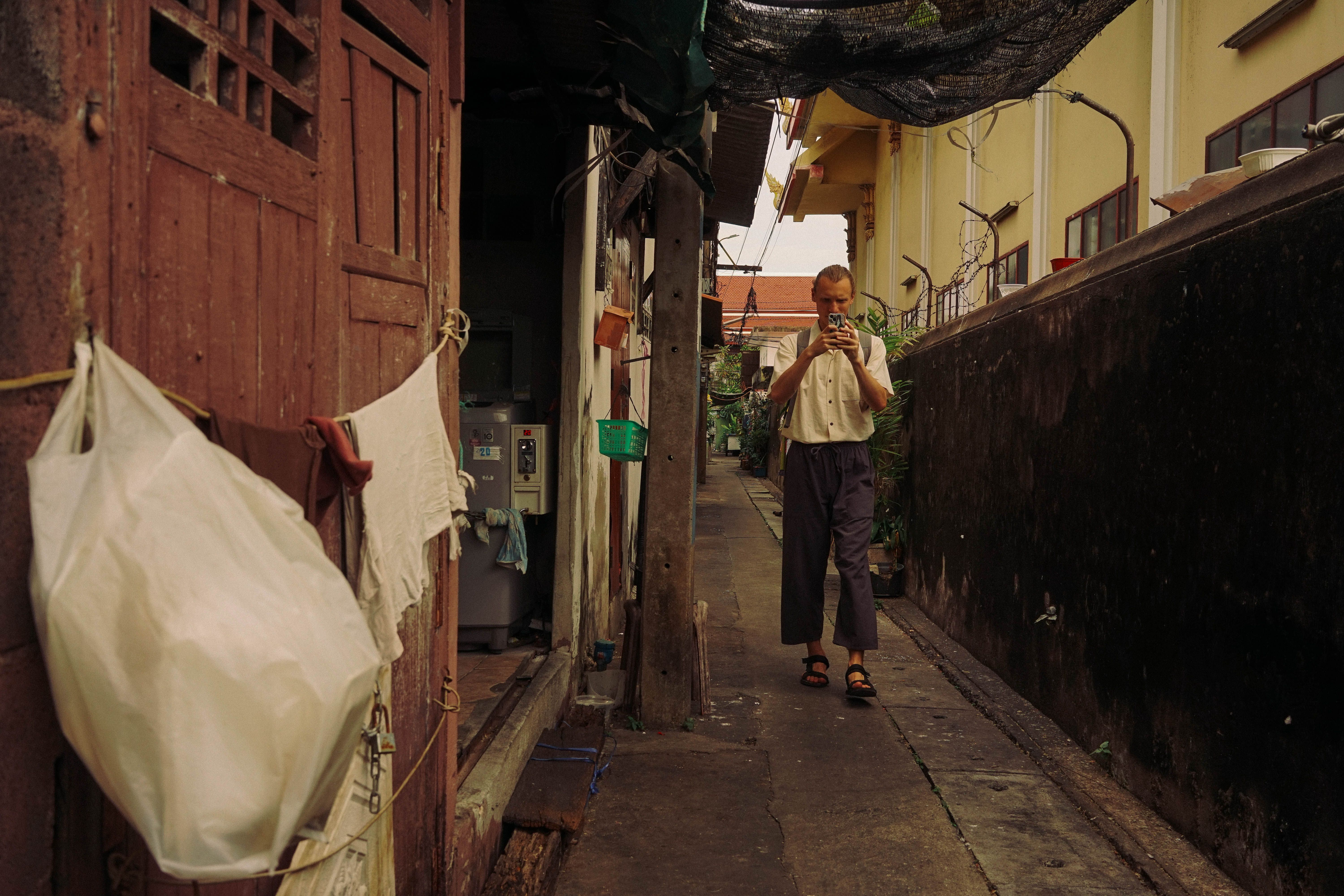 Man Exploring Narrow Alleyway in Bangkok · Free Stock Photo