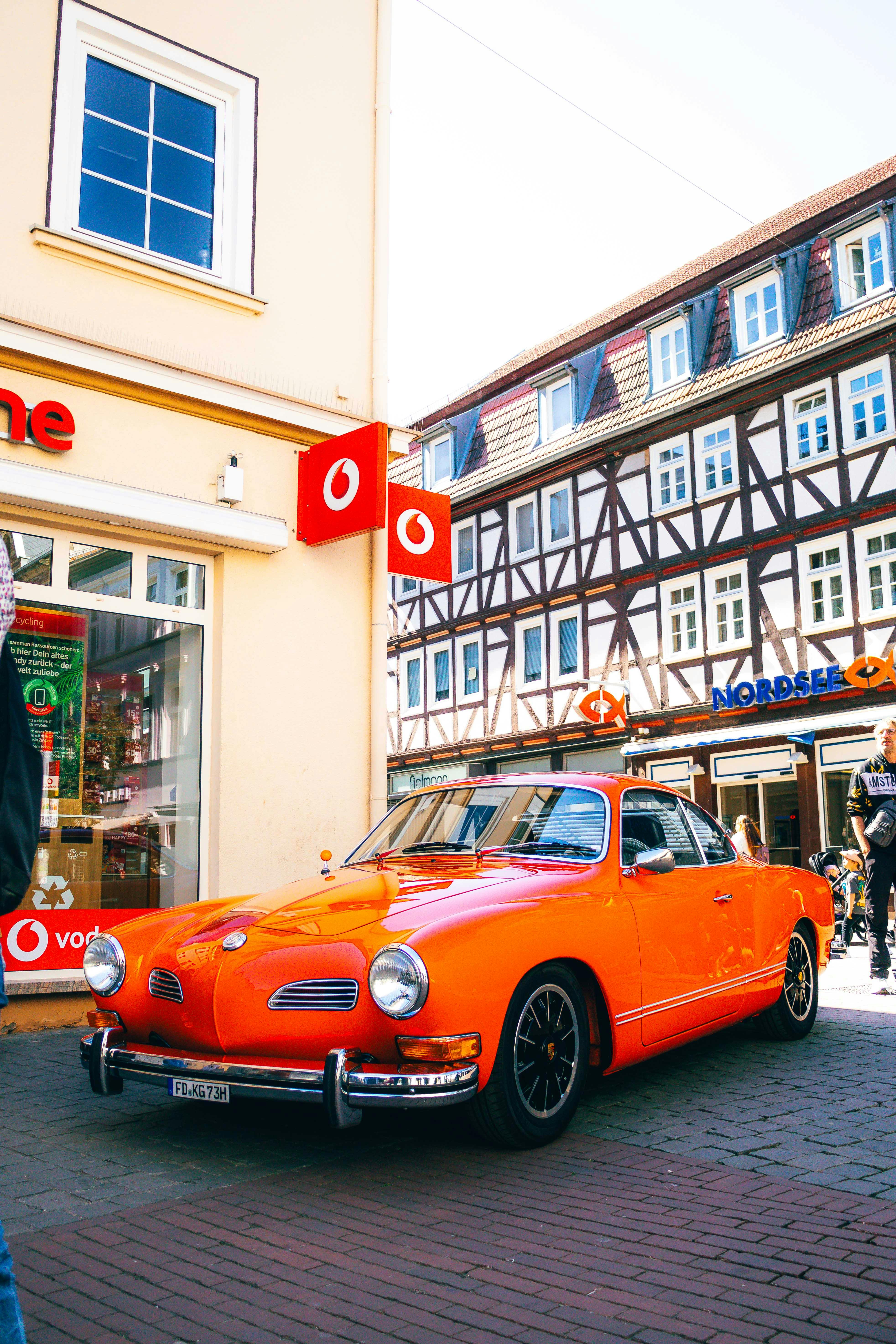 Vintage Orange Car in European Street Scene · Free Stock Photo