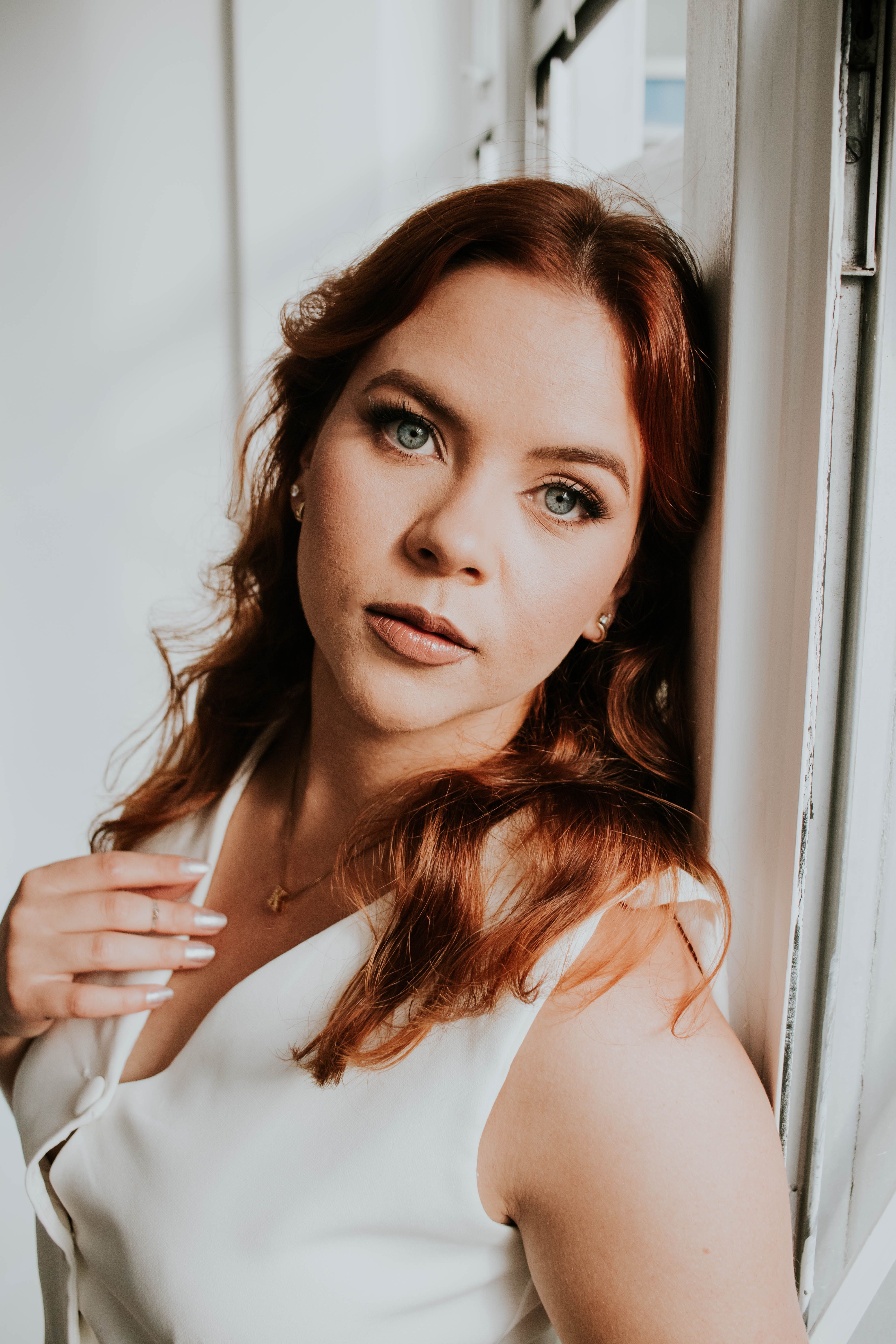 Portrait of a Young Woman Leaning by a Window · Free Stock Photo