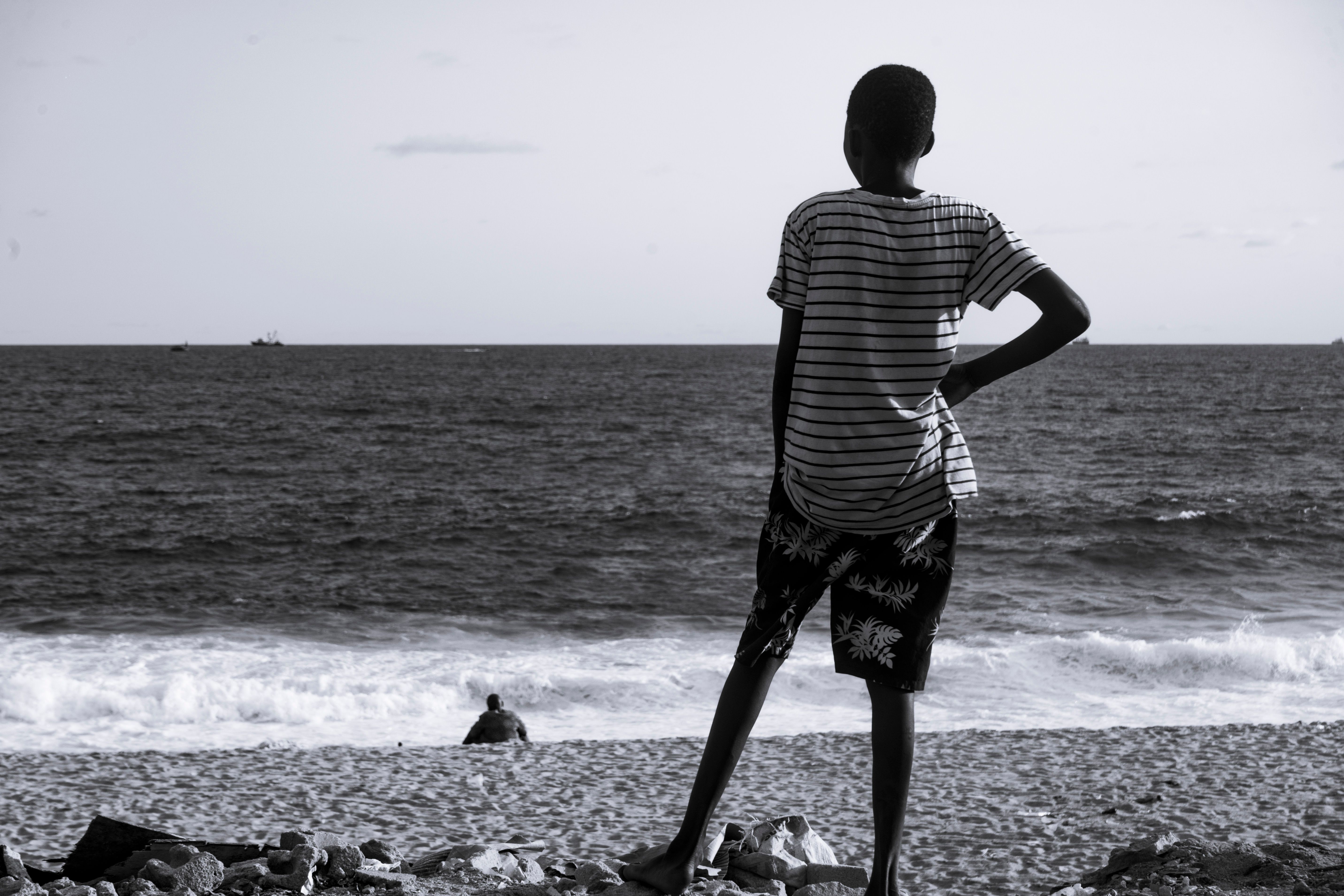 Young Boy Gazing at Ocean's Horizon · Free Stock Photo