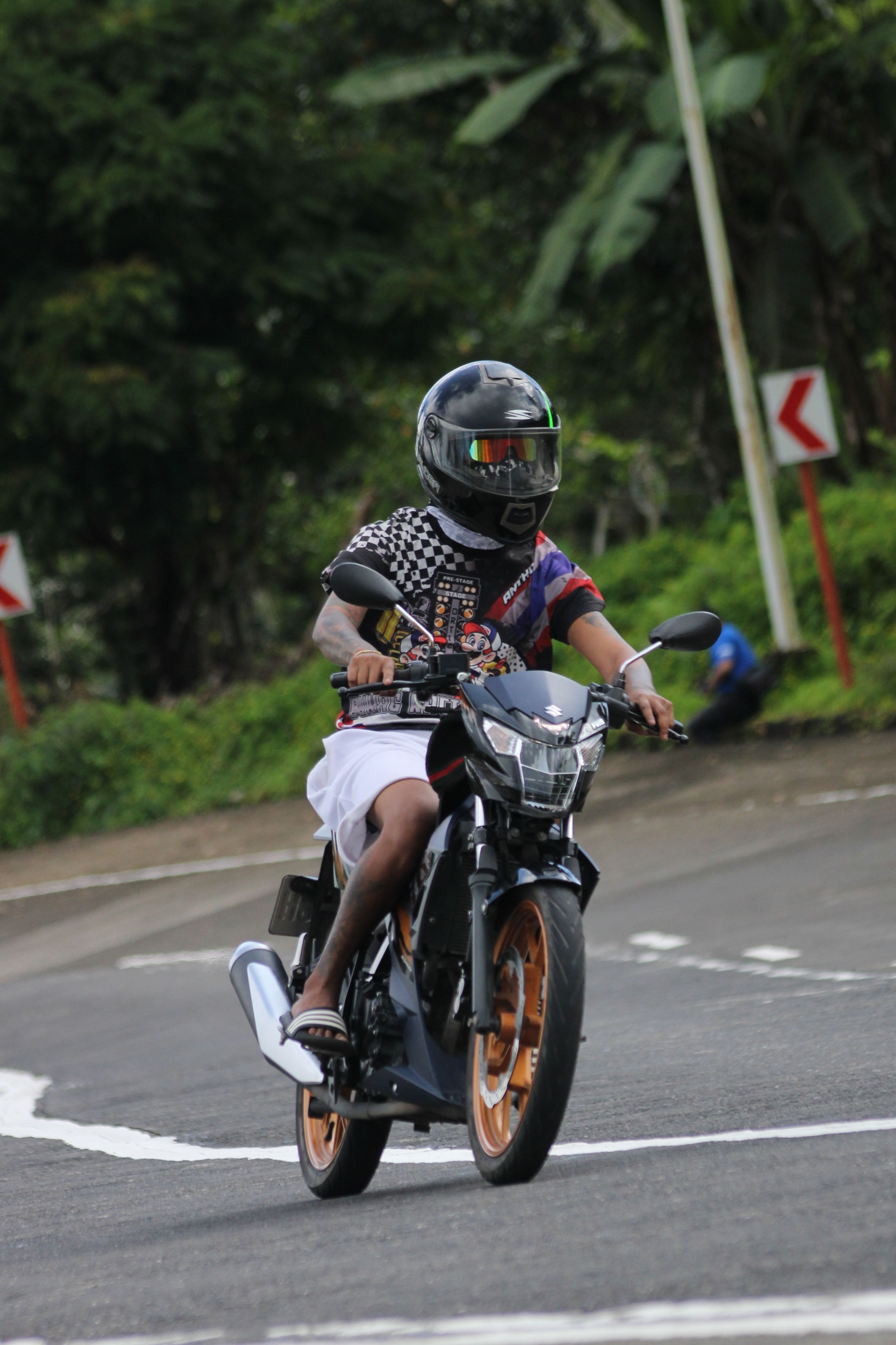 Motorcyclist Maneuvering a Curve on Rural Road · Free Stock Photo