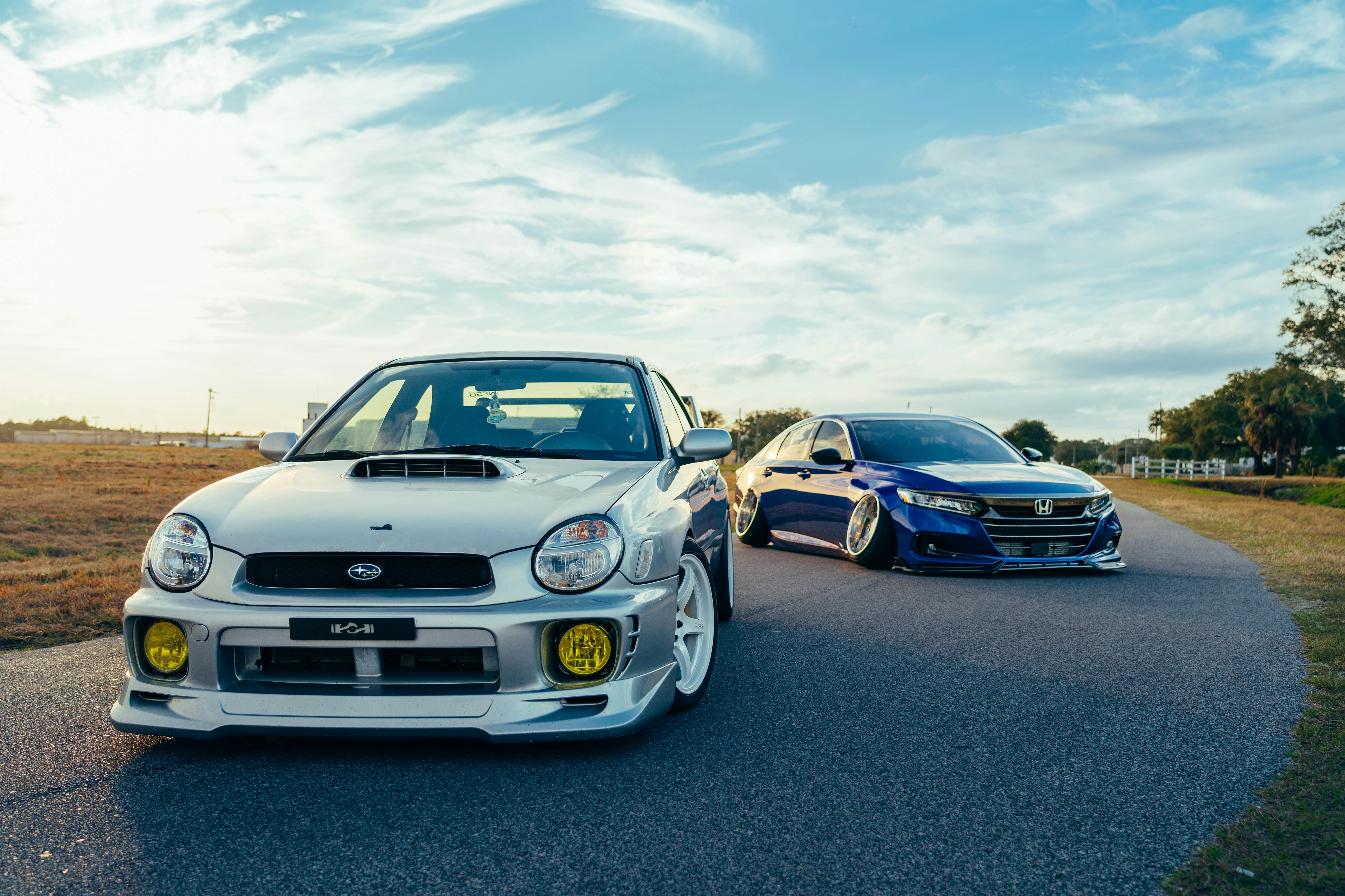 Modified cars on scenic road at sunset · Free Stock Photo