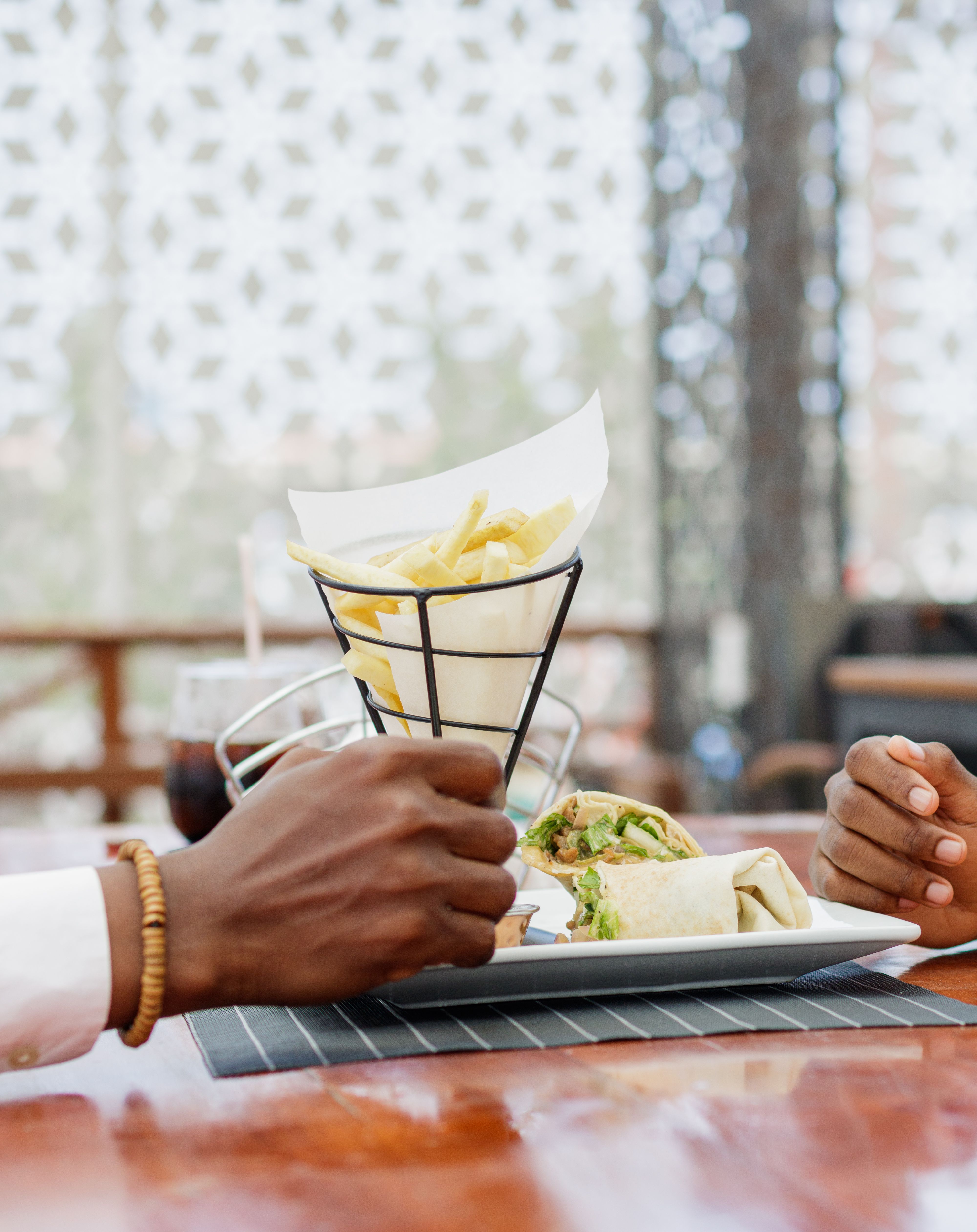 Casual Dining in Accra with French Fries and Wrap · Free Stock Photo
