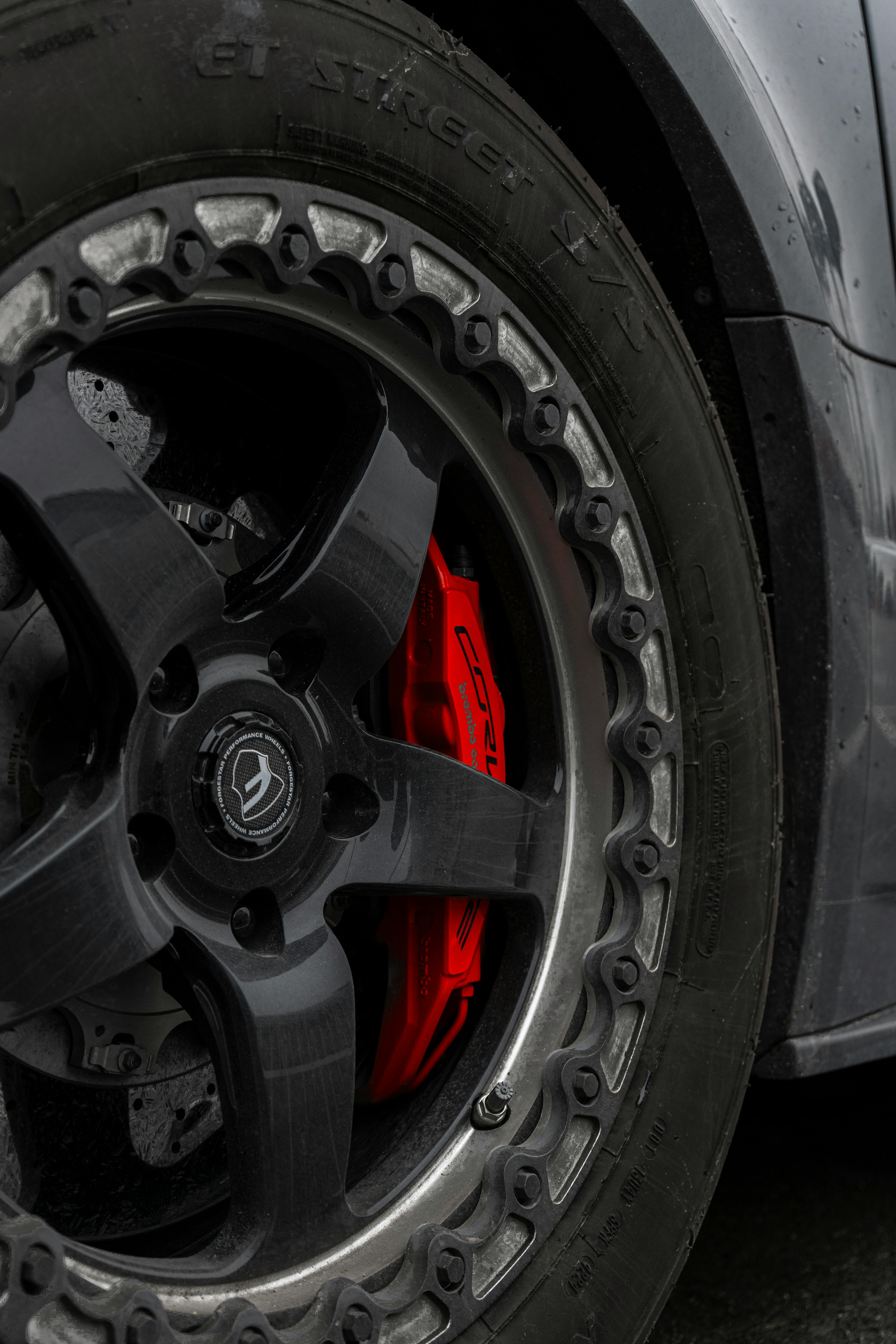 Close-Up of Car Wheel and Red Brake Caliper · Free Stock Photo