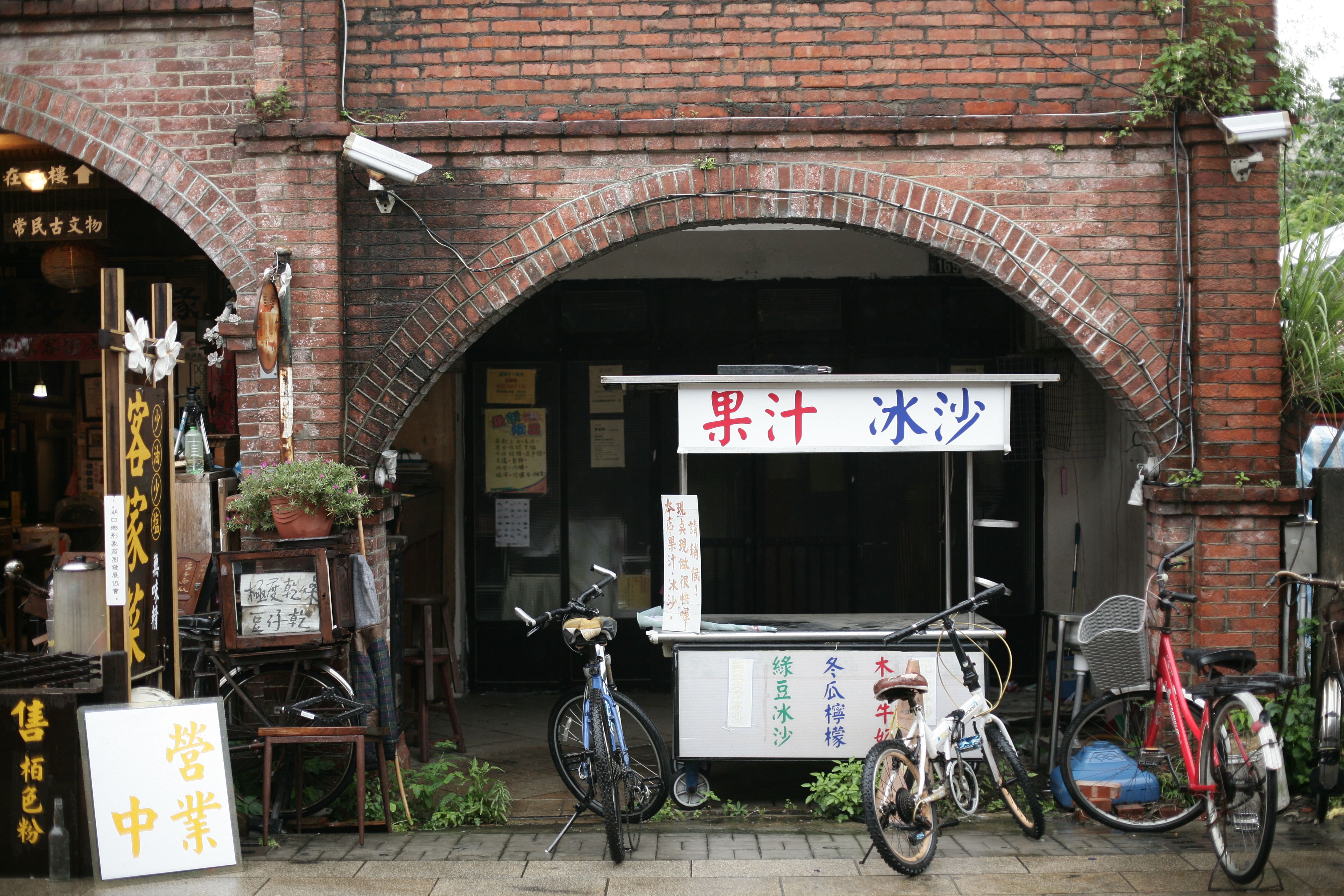Charming Street Scene with Bicycle and Vendor Cart · Free Stock Photo
