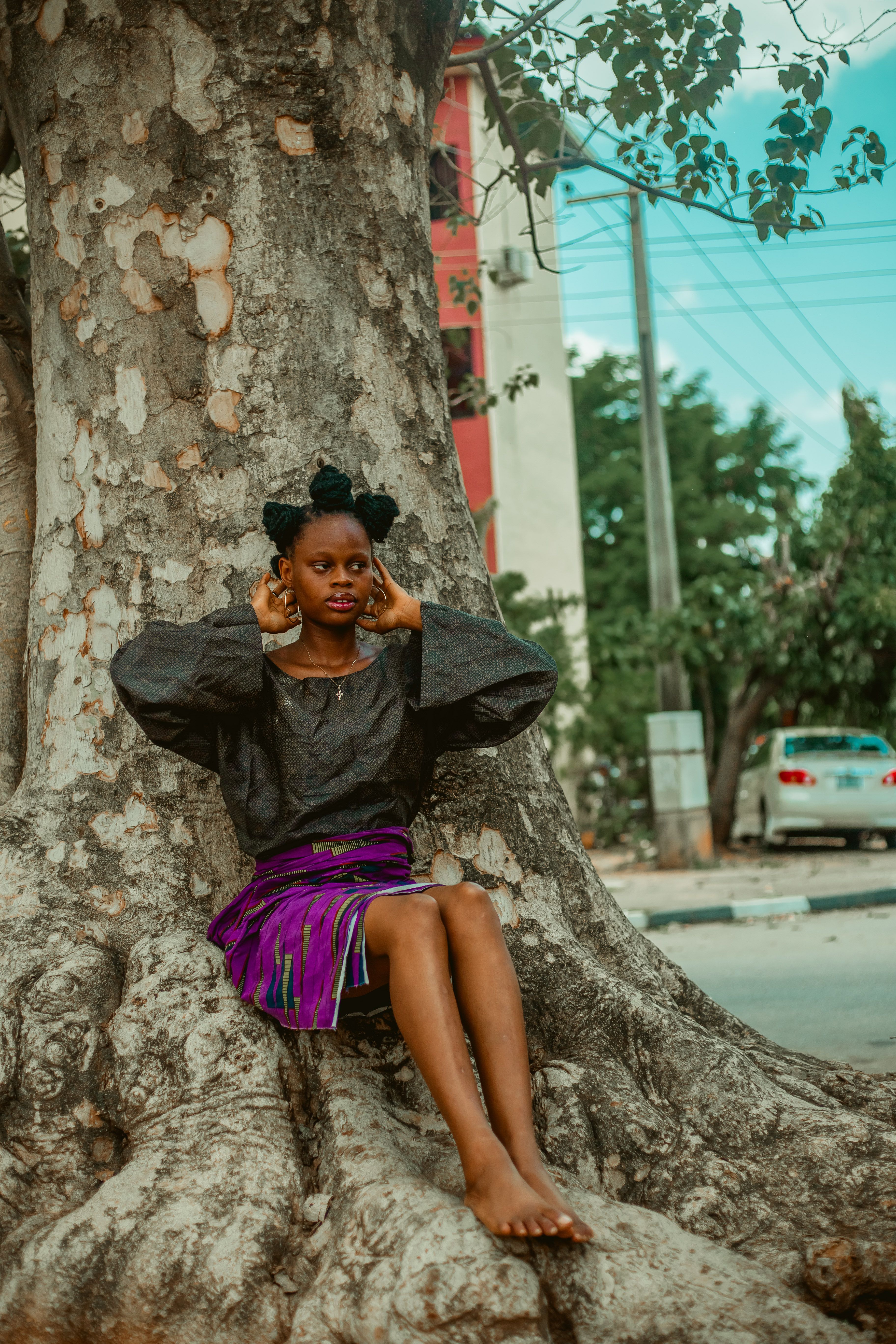 Young Woman Relaxing Under Tree in Urban Setting · Free Stock Photo