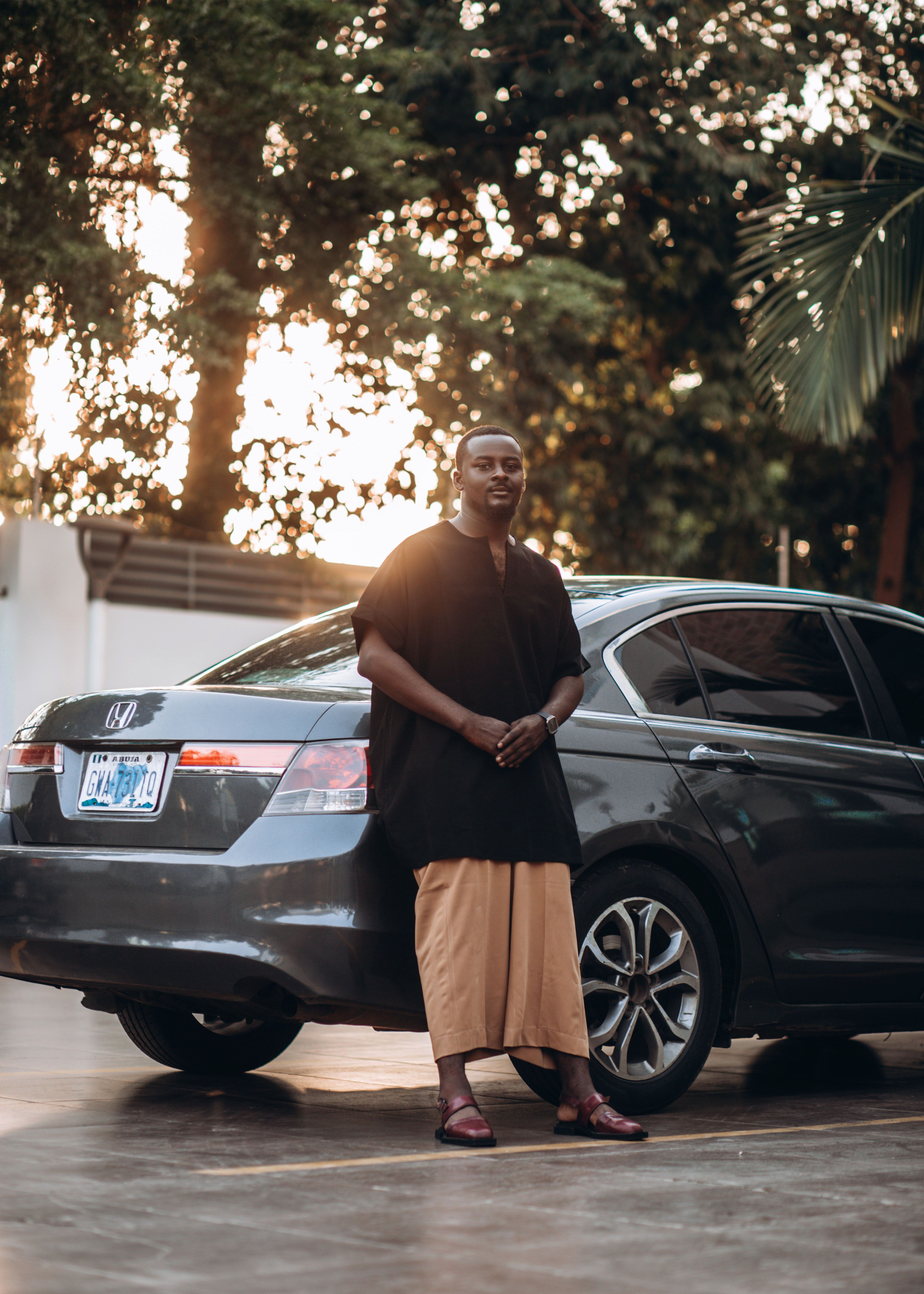 Man standing by car in urban sunset · Free Stock Photo