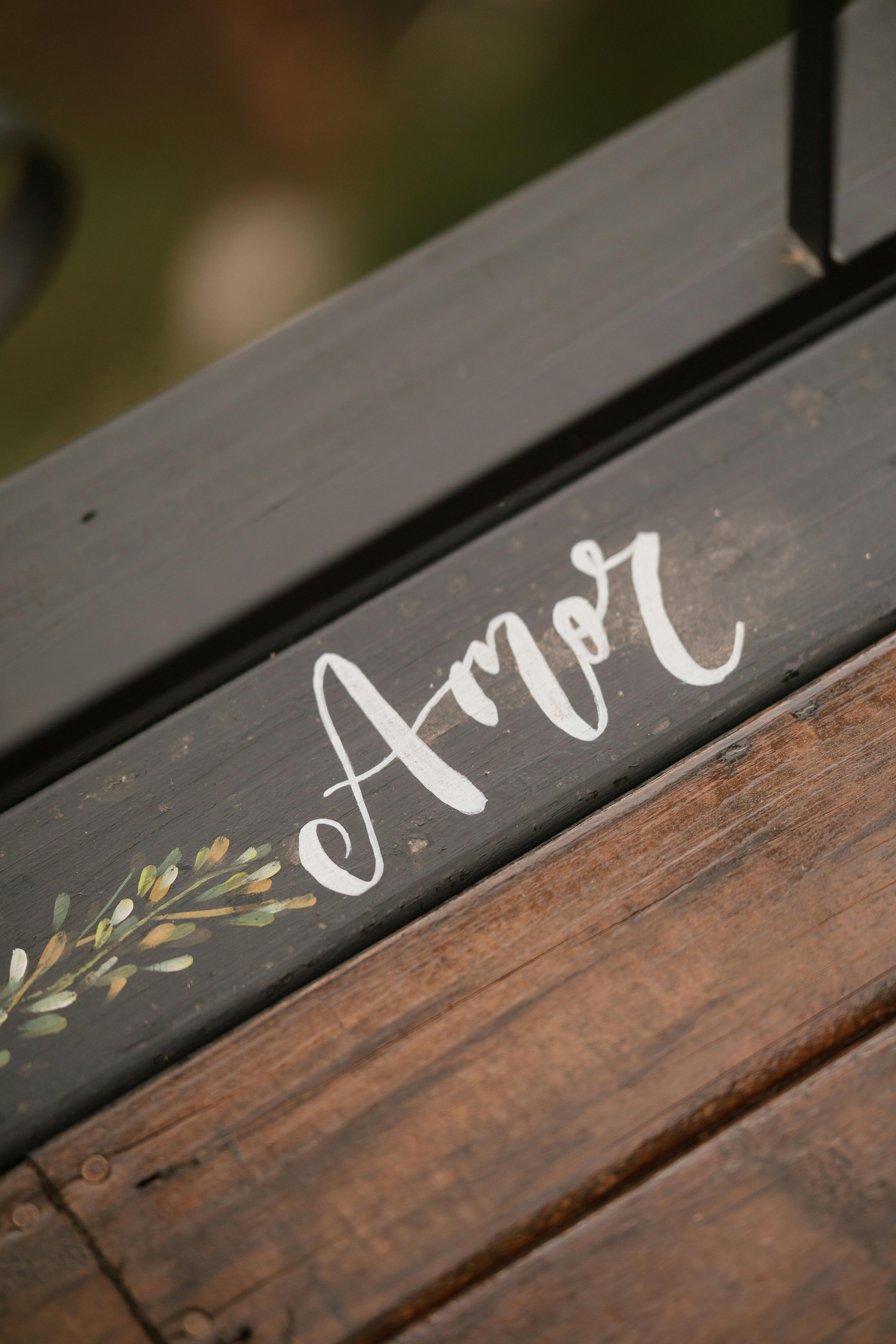 Elegant Hand-Painted 'Amor' Sign on Rustic Wood · Free Stock Photo
