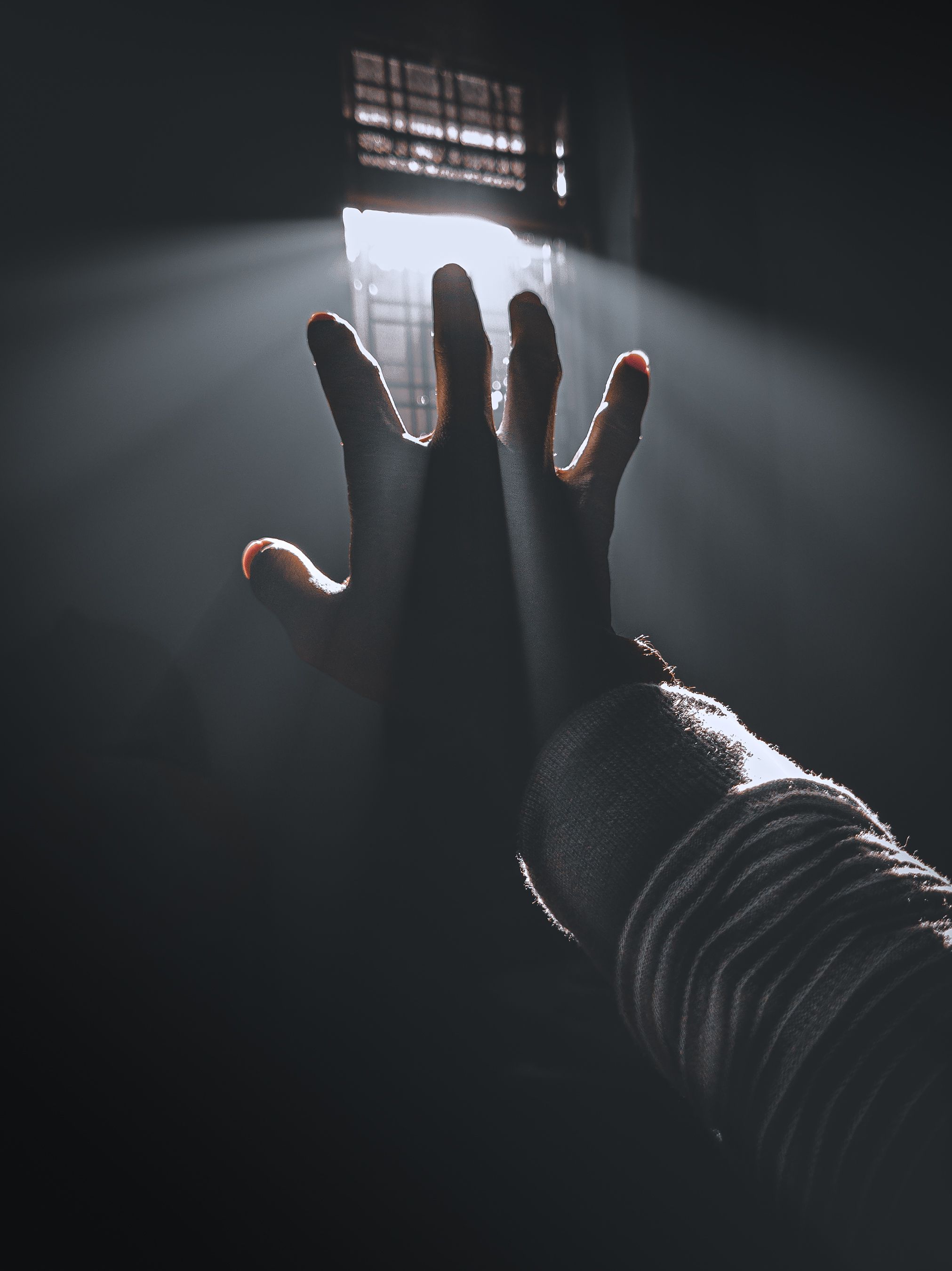 Hand Reaching Towards Light Through Window · Free Stock Photo