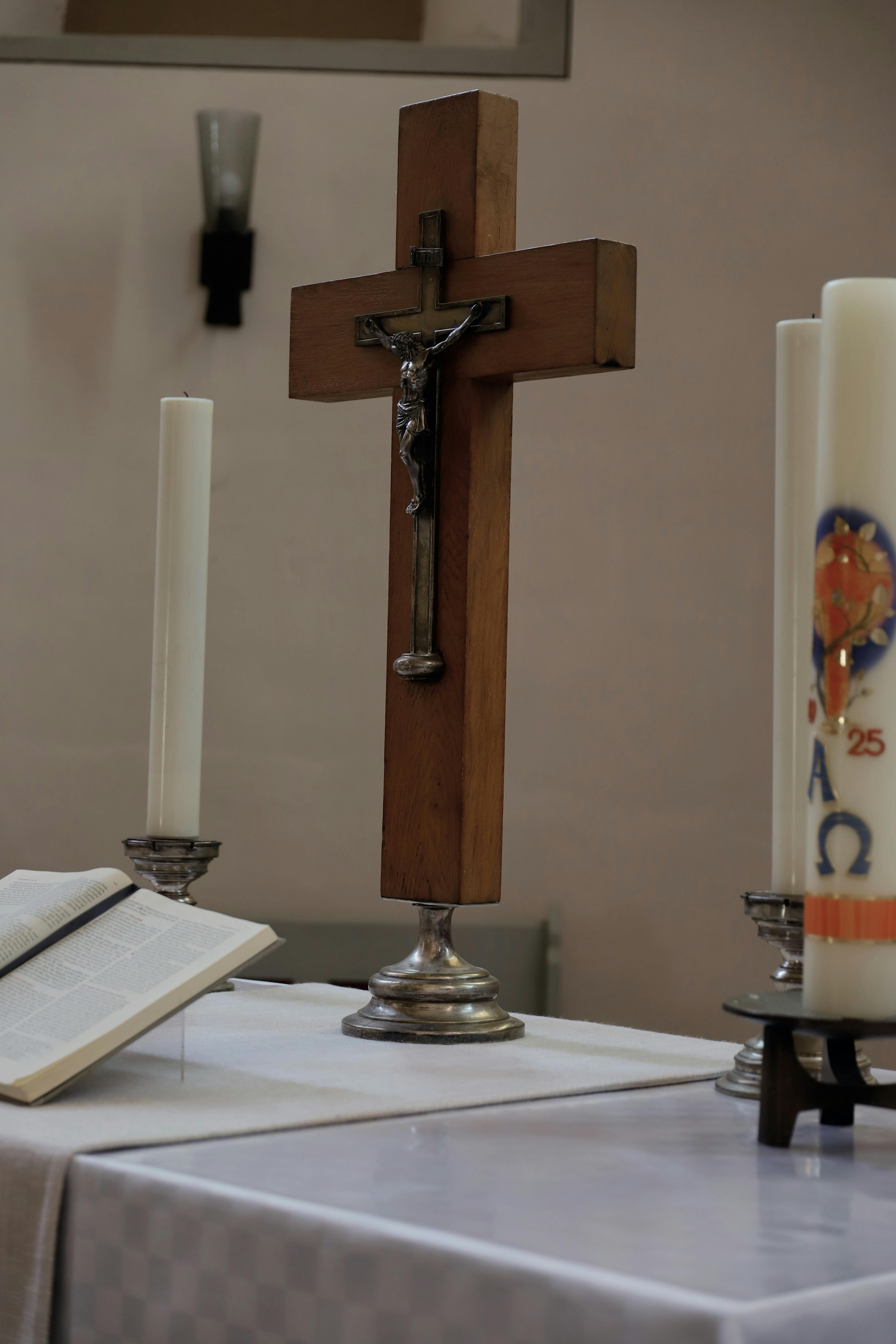 Wooden Altar Cross with Candles and Open Bible · Free Stock Photo