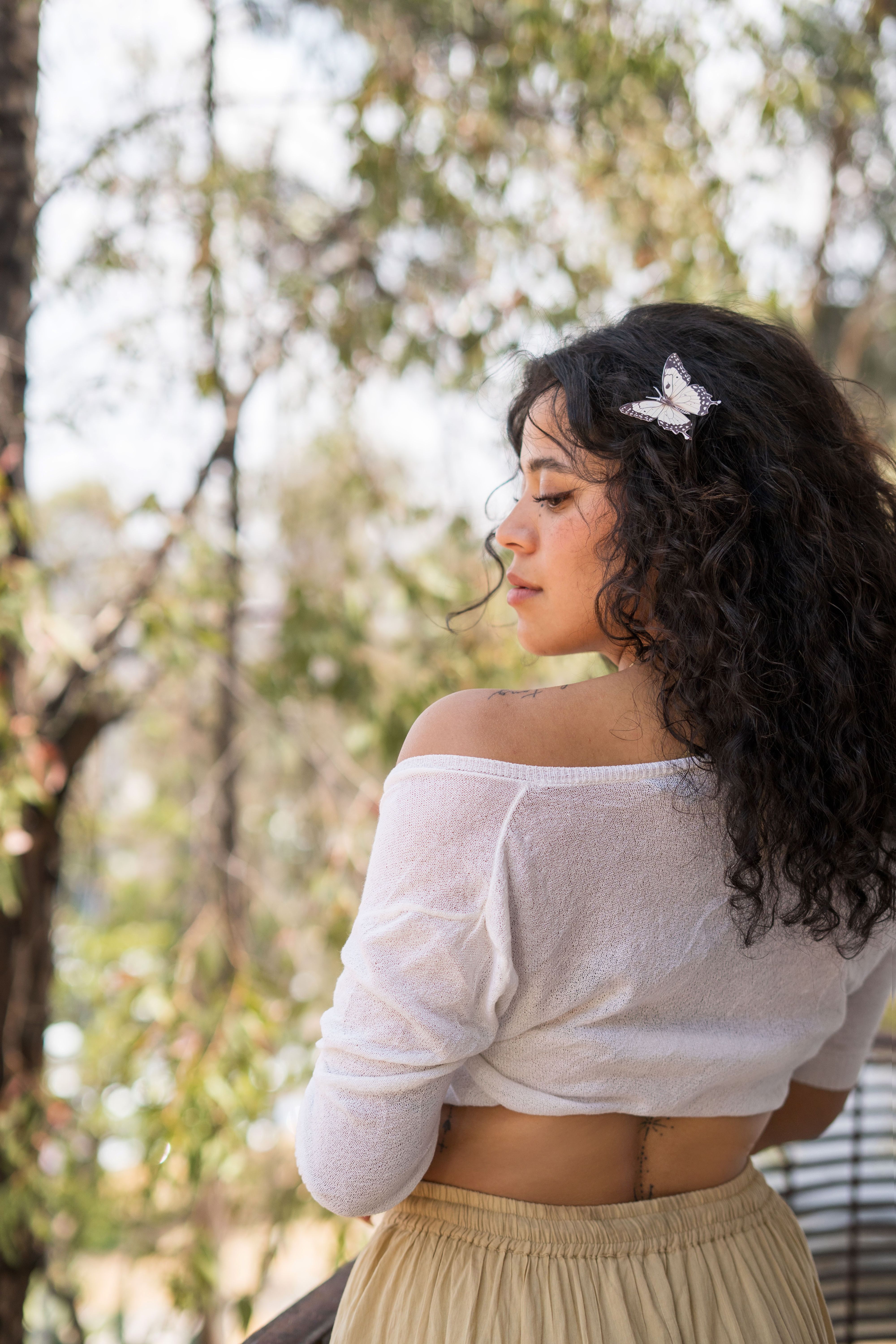 Serene Outdoor Portrait of a Woman with Curly Hair · Free Stock Photo