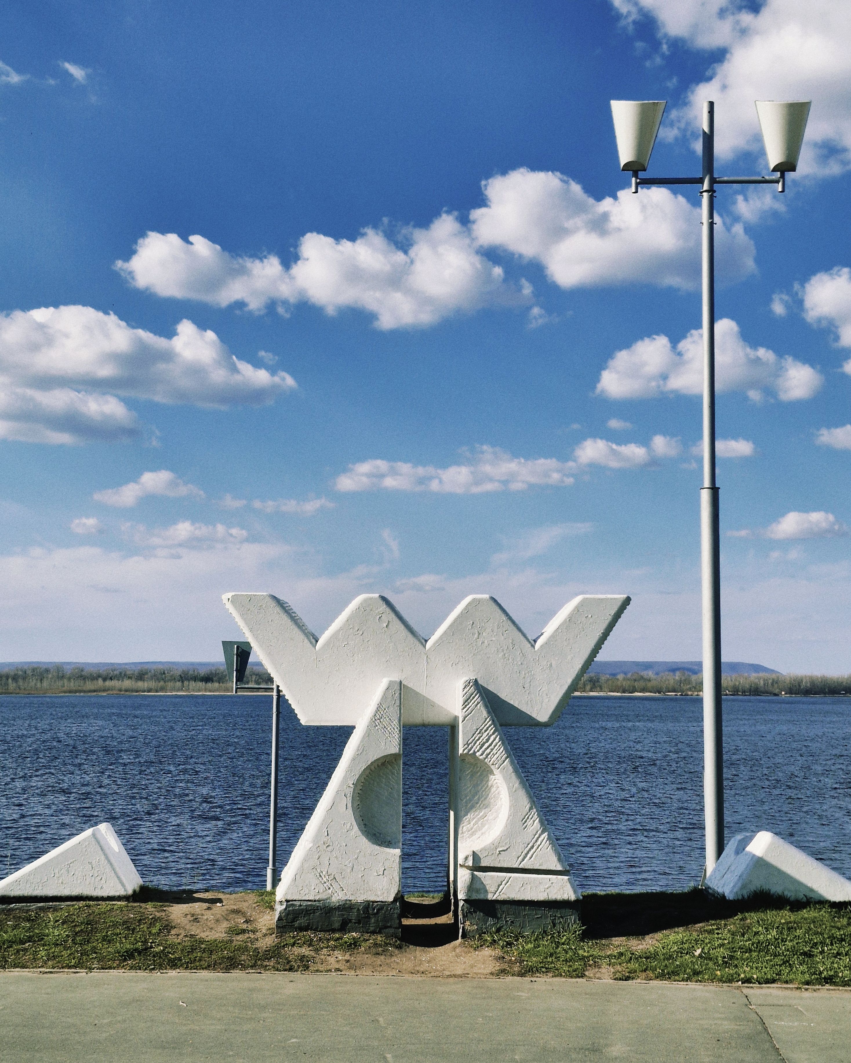 Scenic Lakeside View with Sculpture and Lamp Post · Free Stock Photo