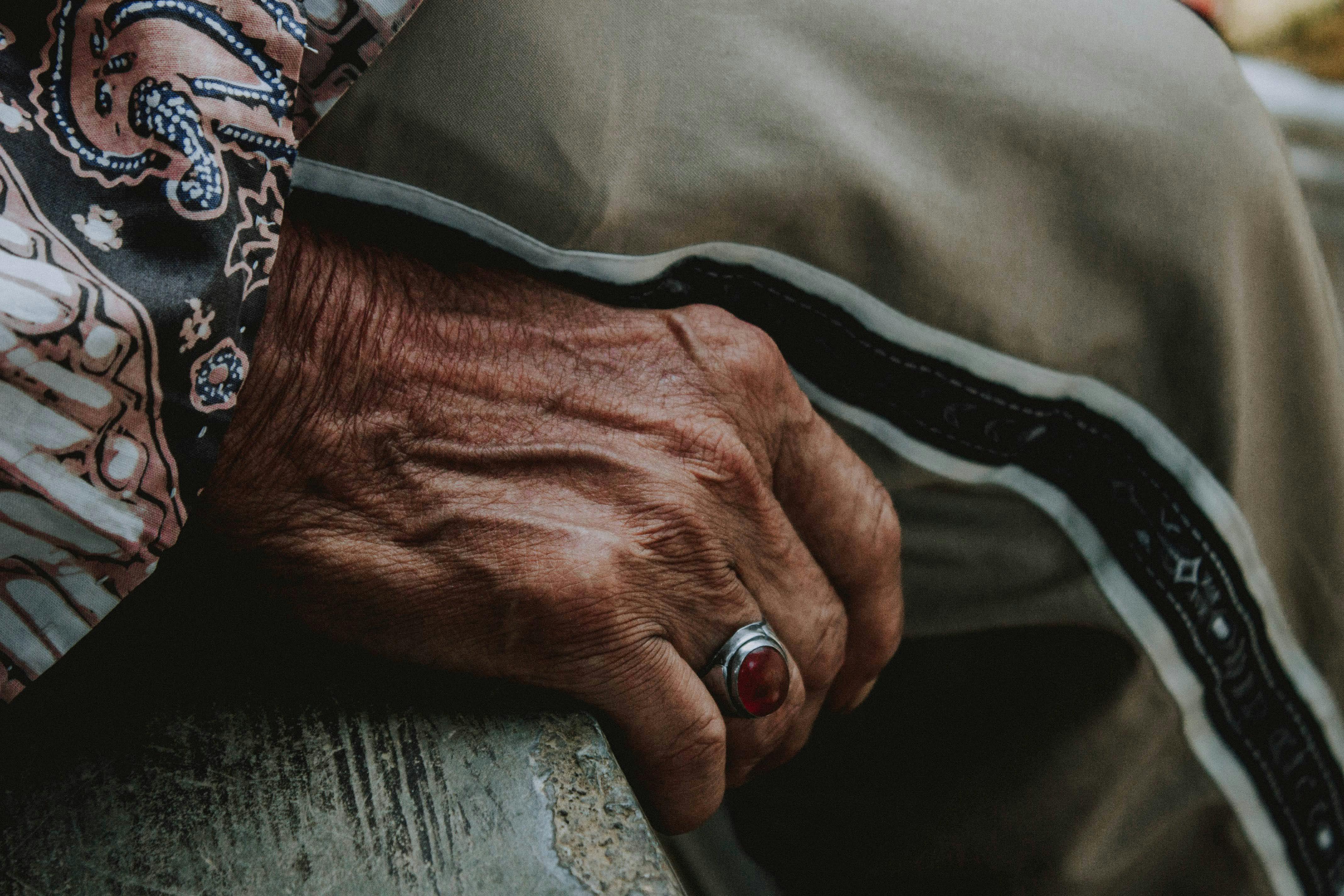 Aging hand with ring in traditional clothing · Free Stock Photo
