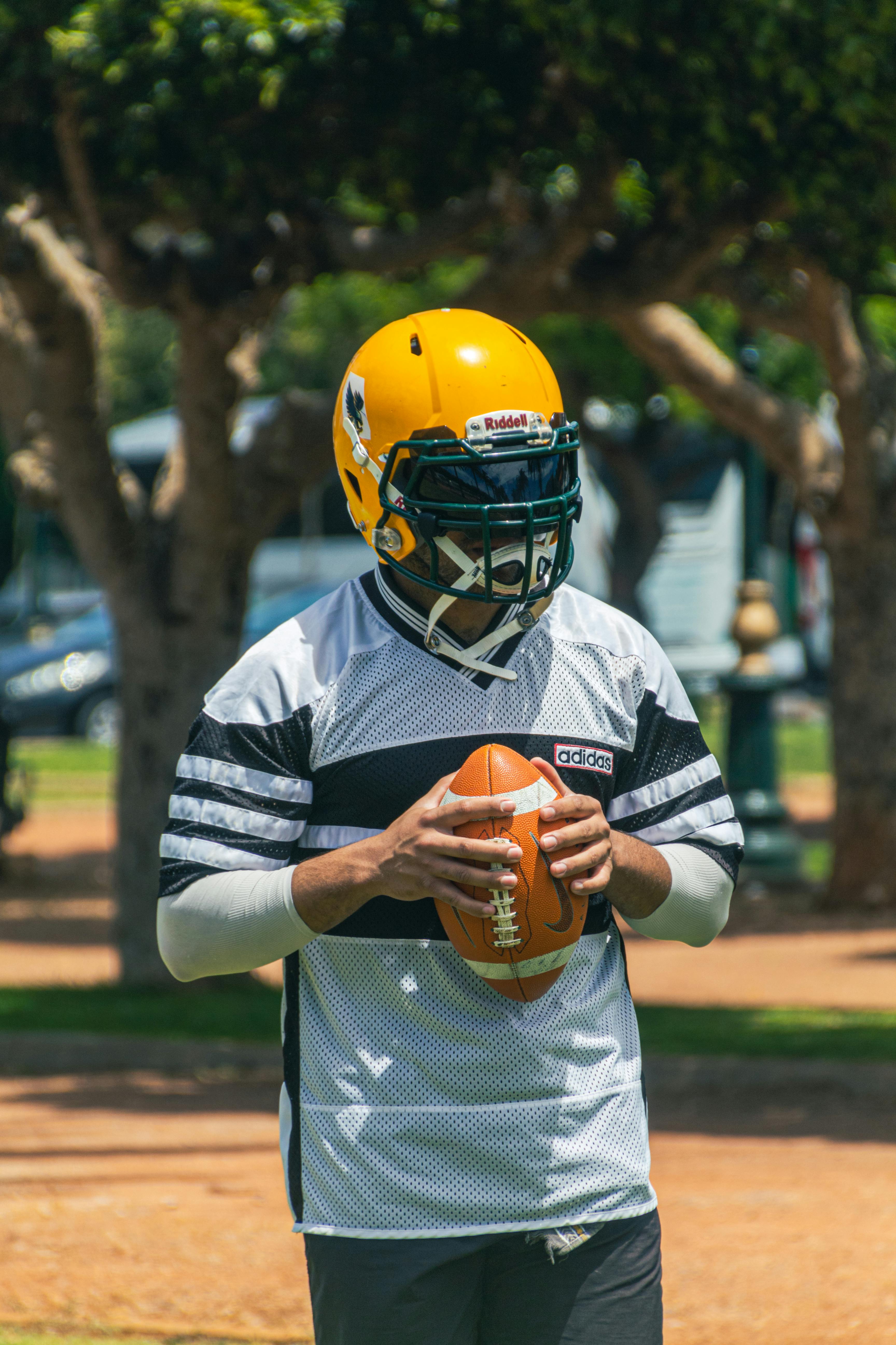 Jugador De Fútbol Americano Sosteniendo Una Pelota Al Aire Libre · Foto ...