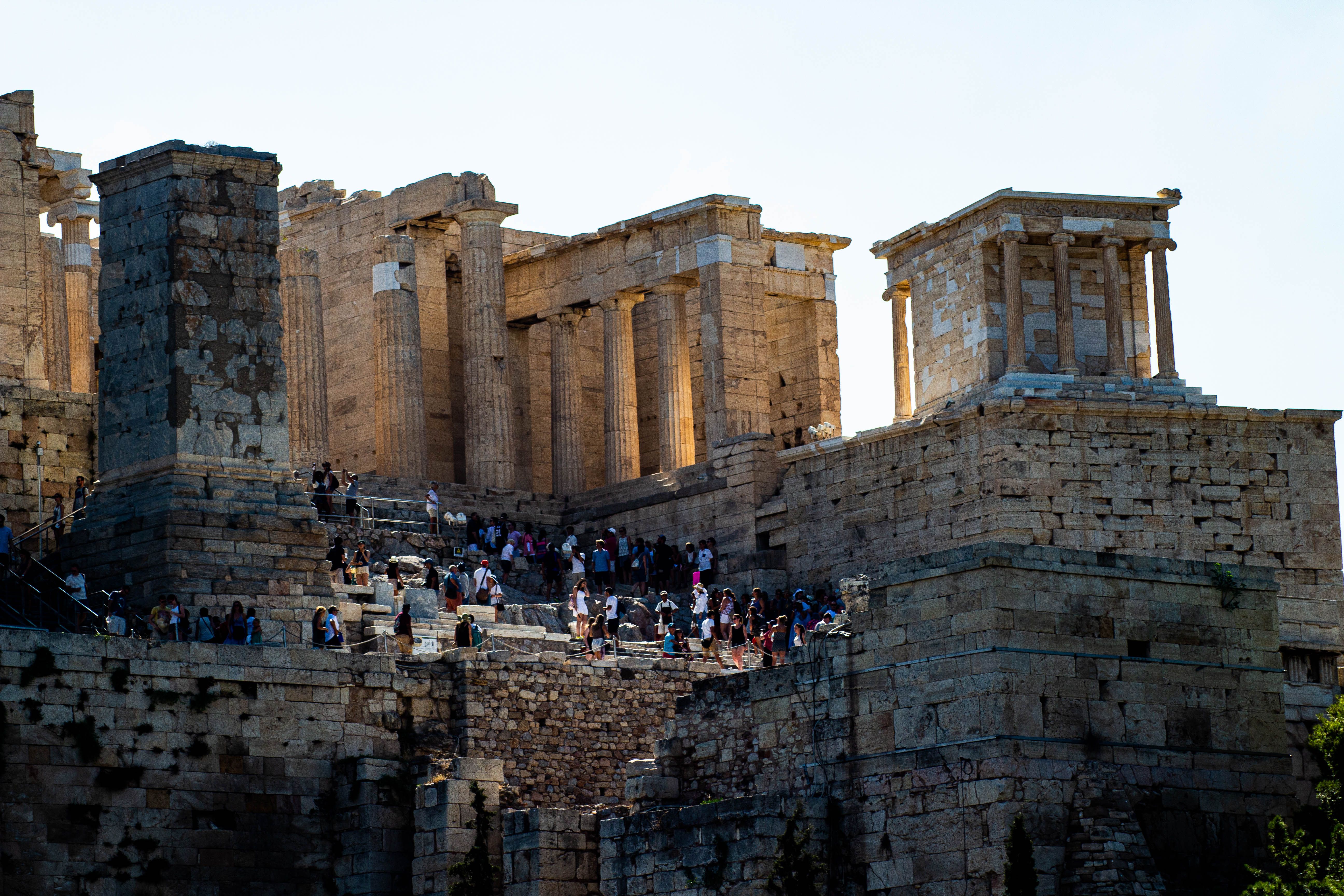 Tourists Exploring the Ancient Acropolis Ruins · Free Stock Photo