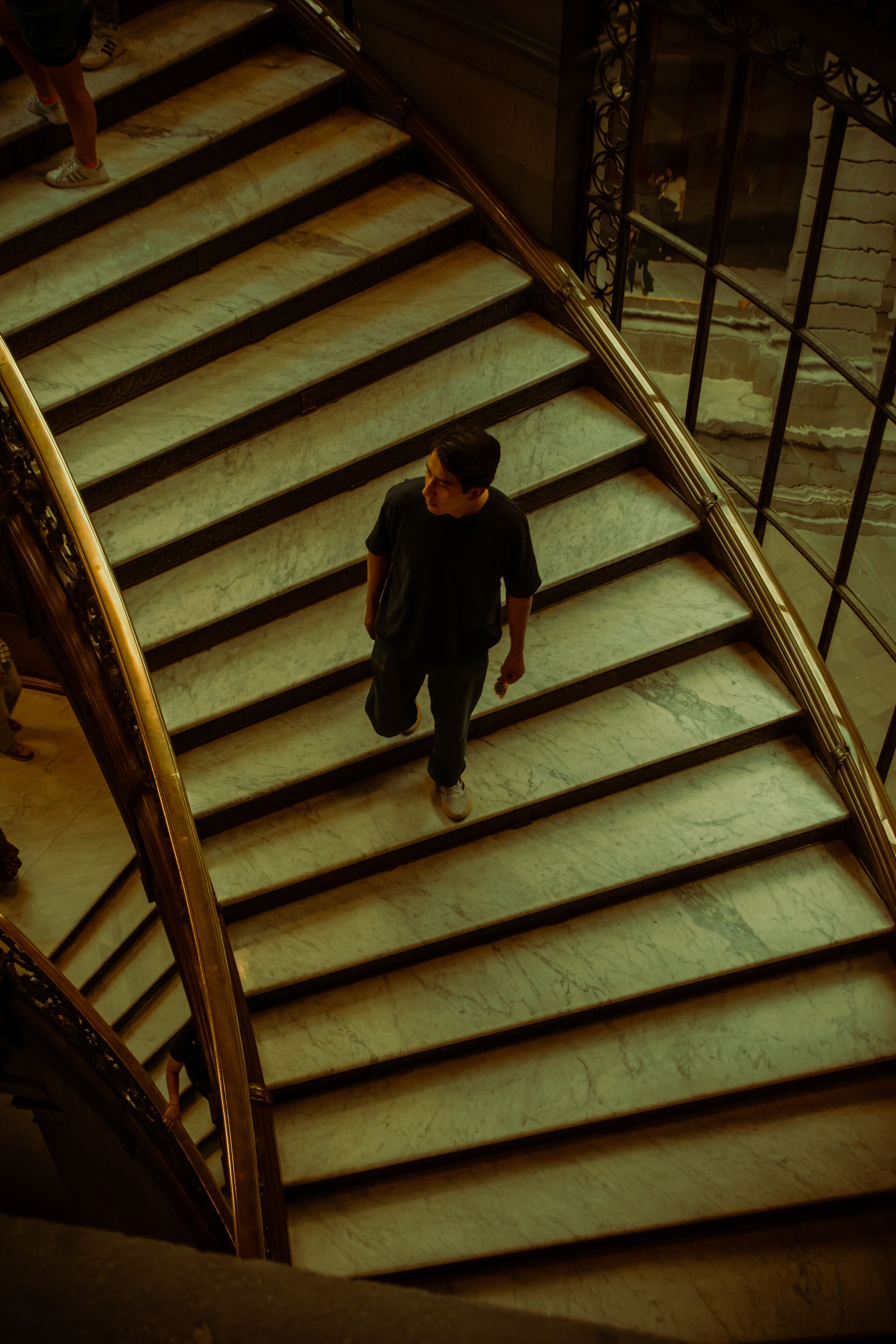 Man Ascending Grand Spiral Staircase Indoors · Free Stock Photo