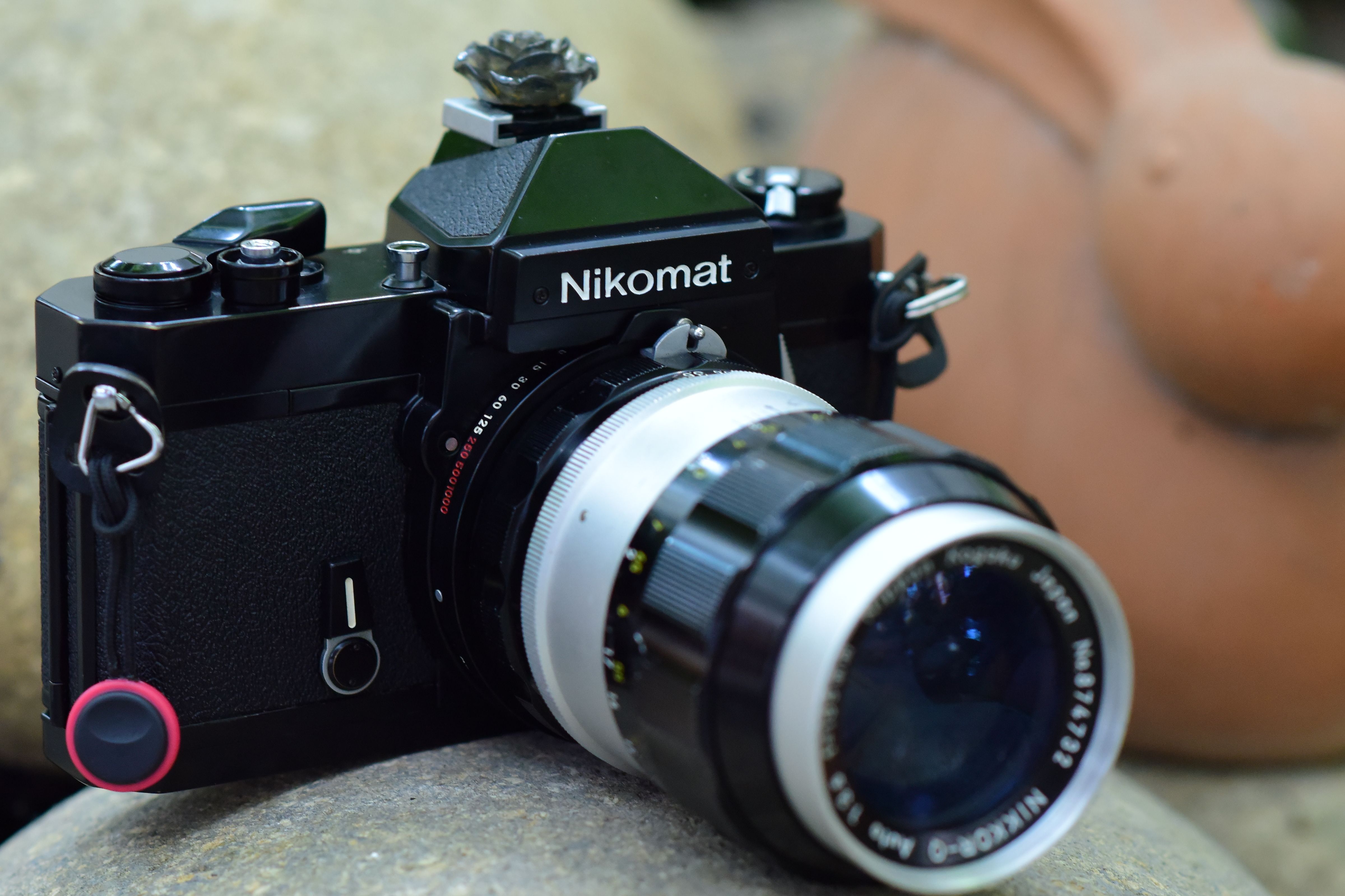 Vintage Nikomat Camera on Stone Surface · Free Stock Photo