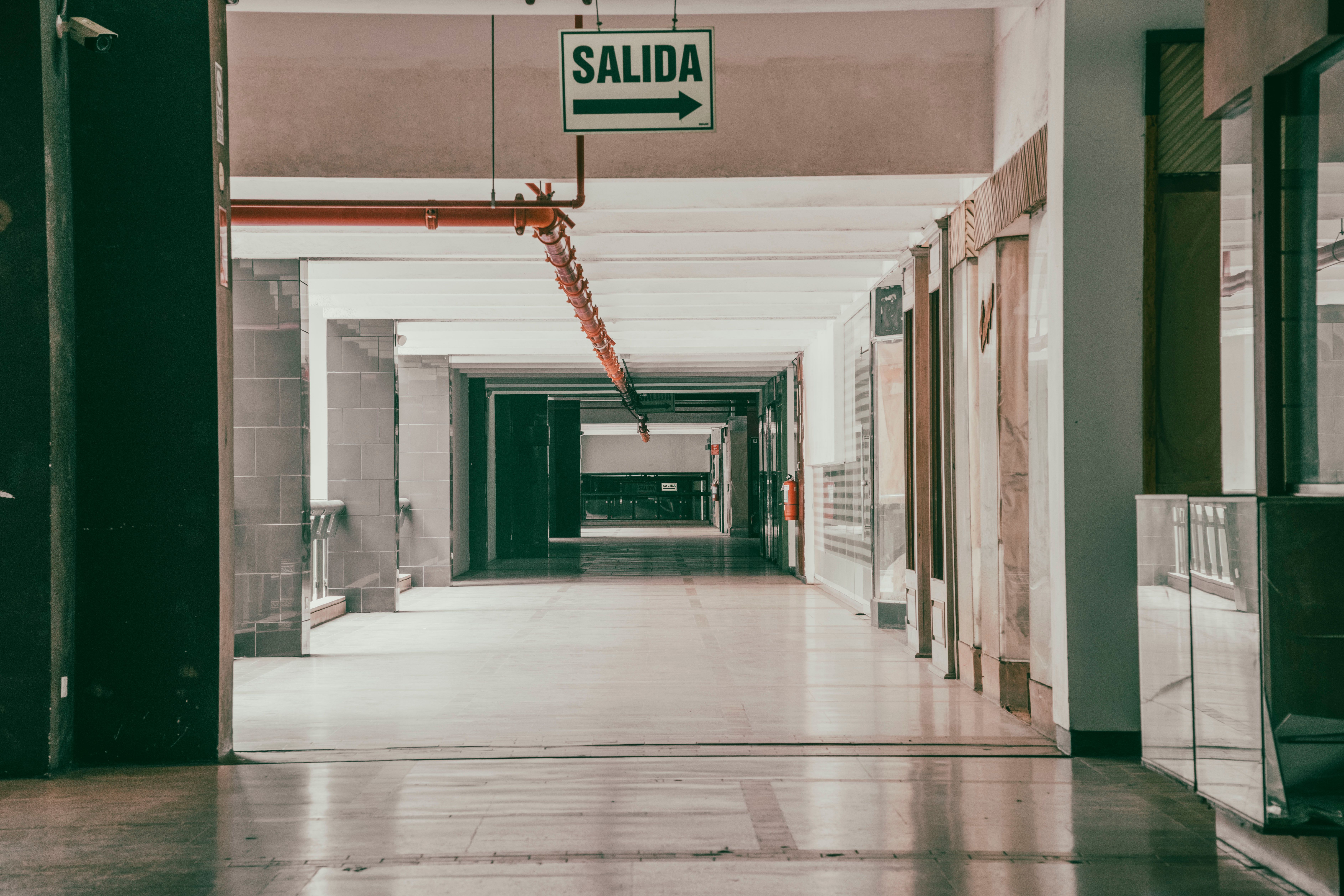 Empty Indoor Corridor with Exit Sign · Free Stock Photo